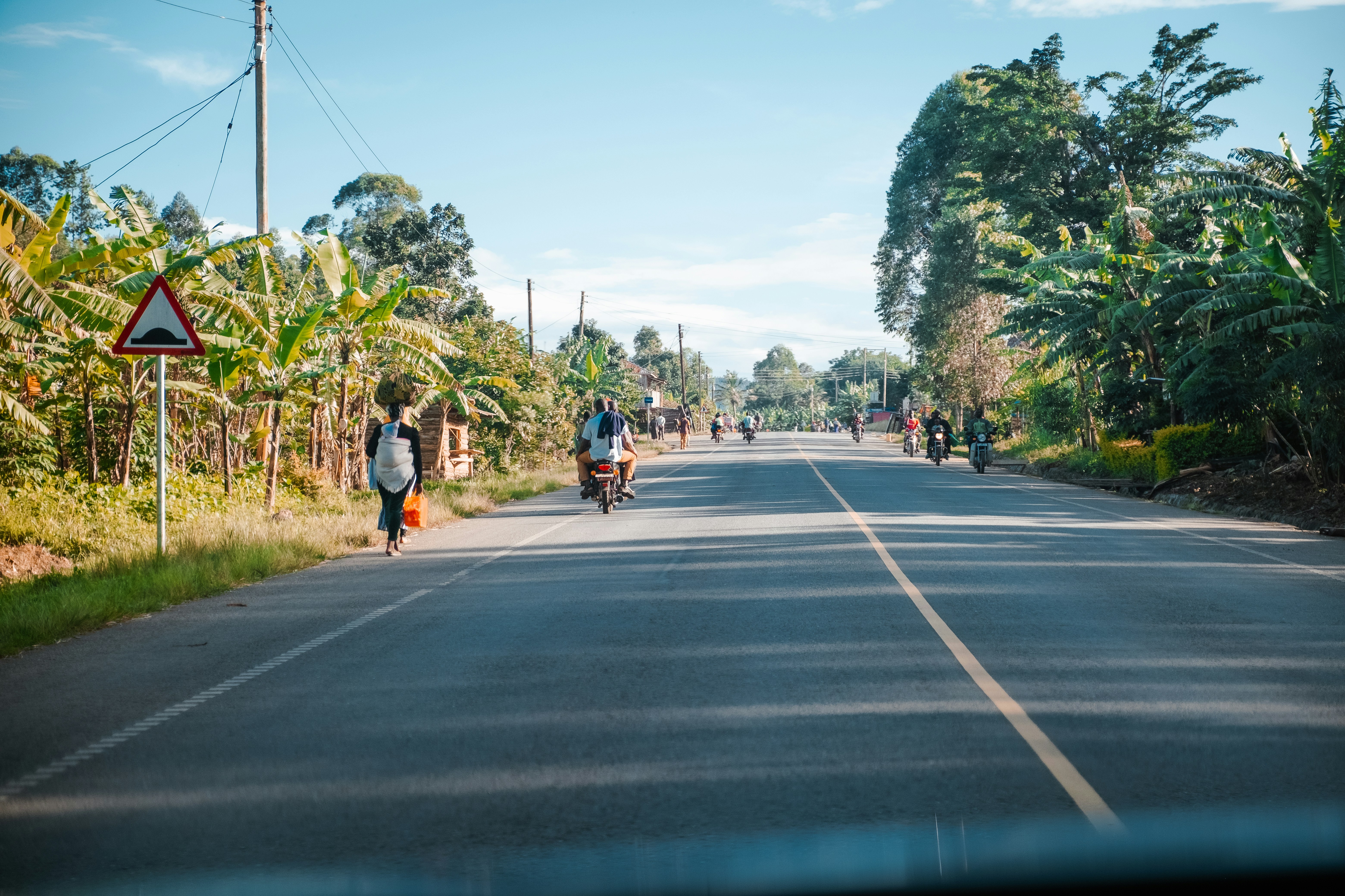 A group of people riding motorcycles down a street photo – Free Road ...
