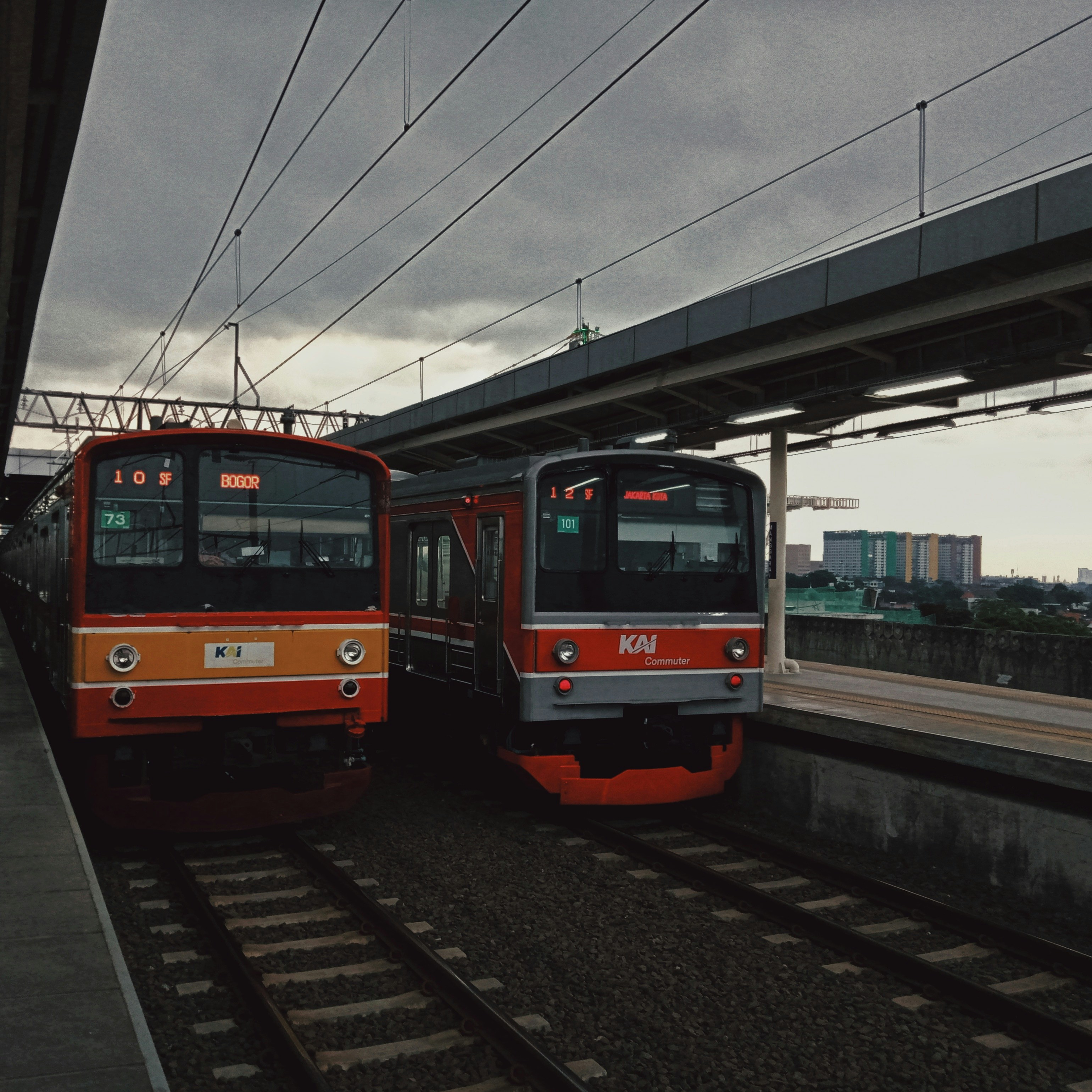 Old Livery (red-yellow-white) and new livery (grey-red-white) of Jabodetabek electric train from Commuterline Indonesia | a couple of trains that are sitting on the tracks