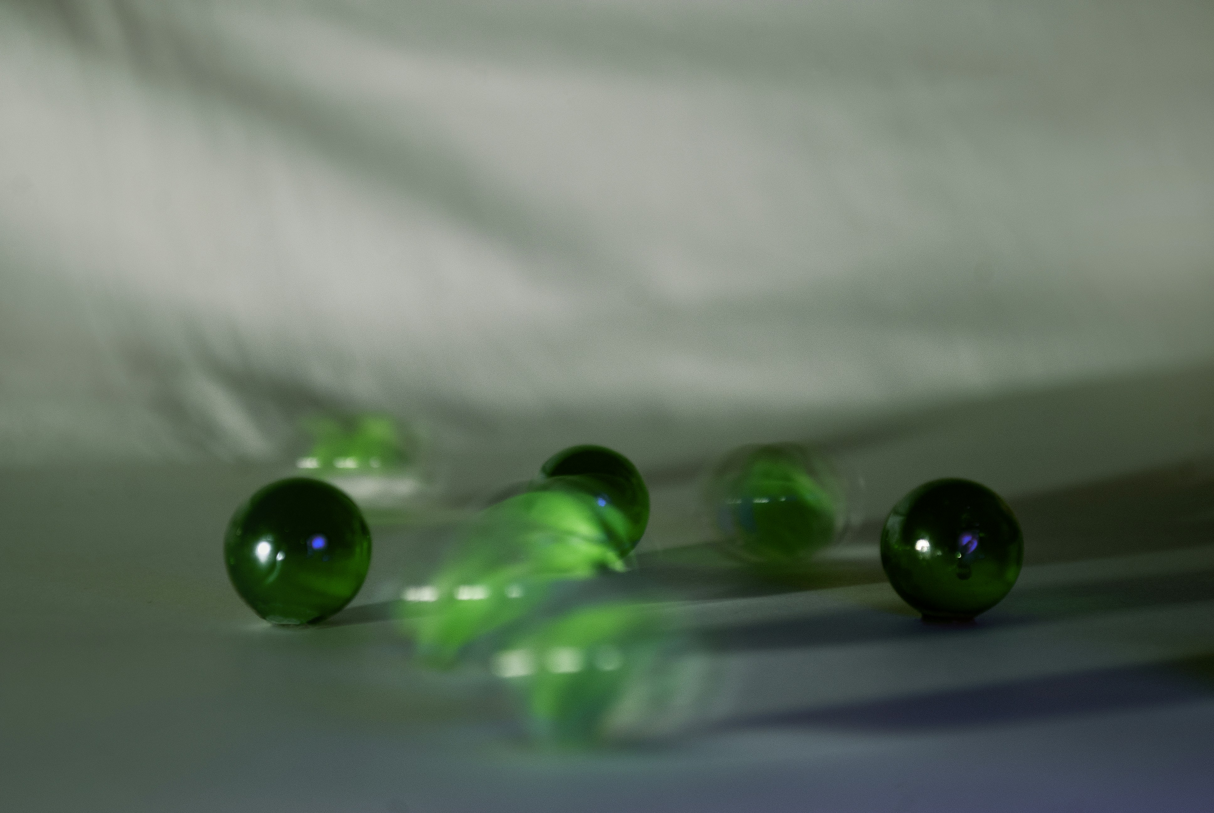 A group of green glass balls sitting on top of a table photo – Free ...