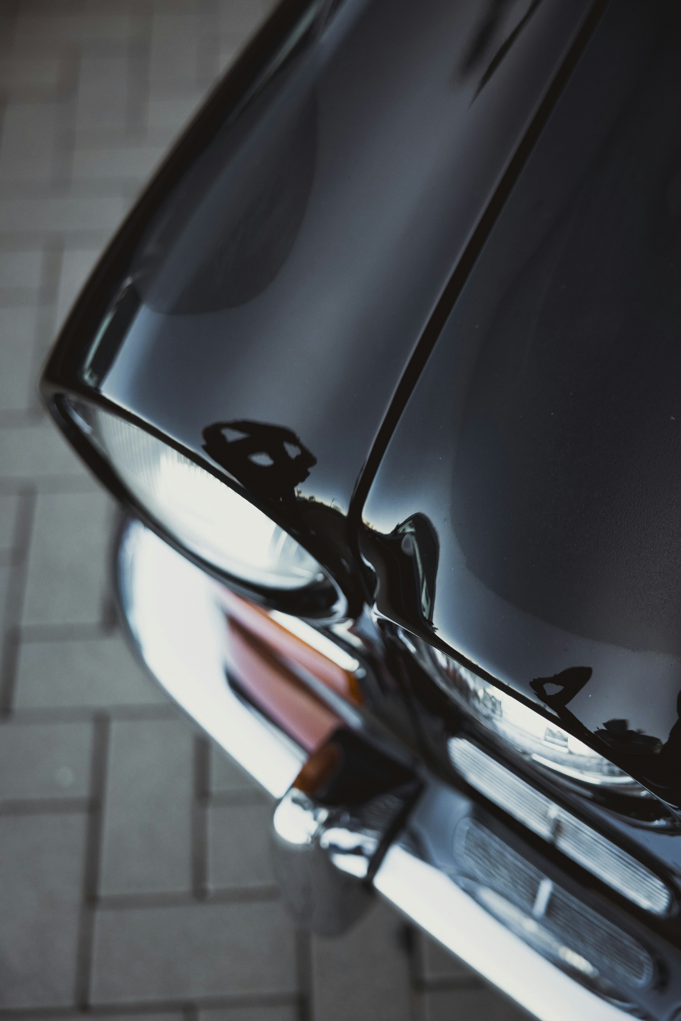 Midnight Gleam: Close-Up of a Vintage Car's Hood and Headlight Reflections