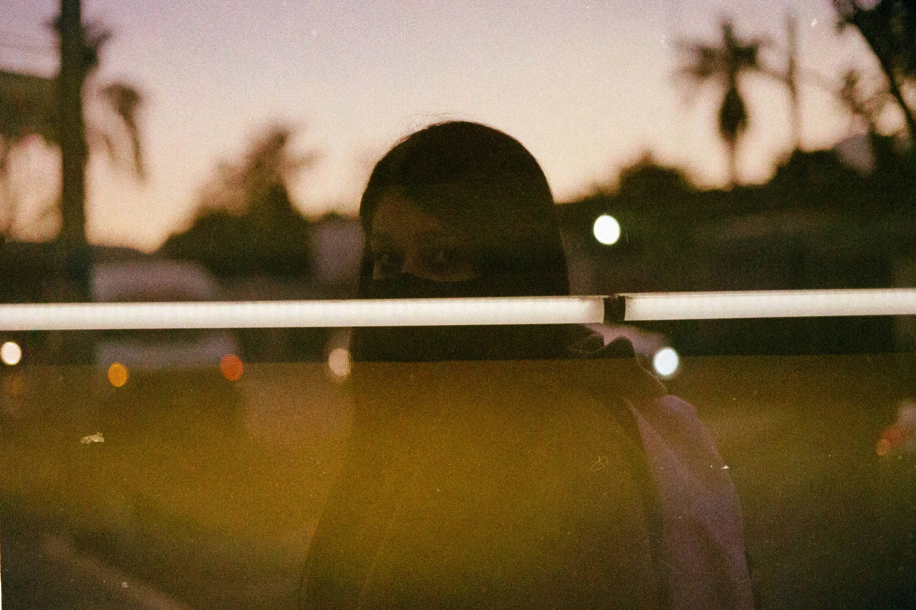 A person looking out a window at the street photo – Free Double ...