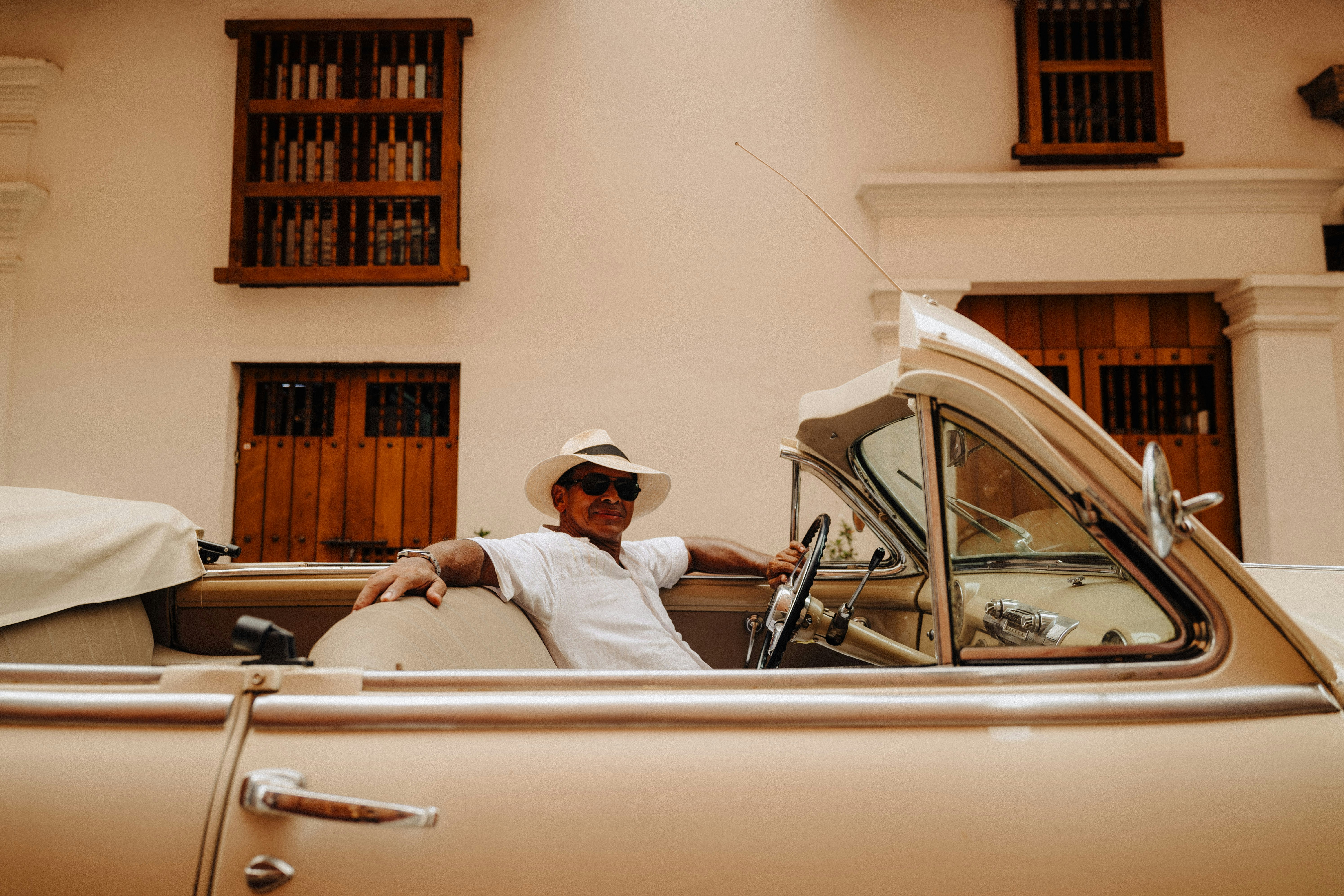 Sunlit Vintage Convertible: Gentleman at Ease on a Warm Street