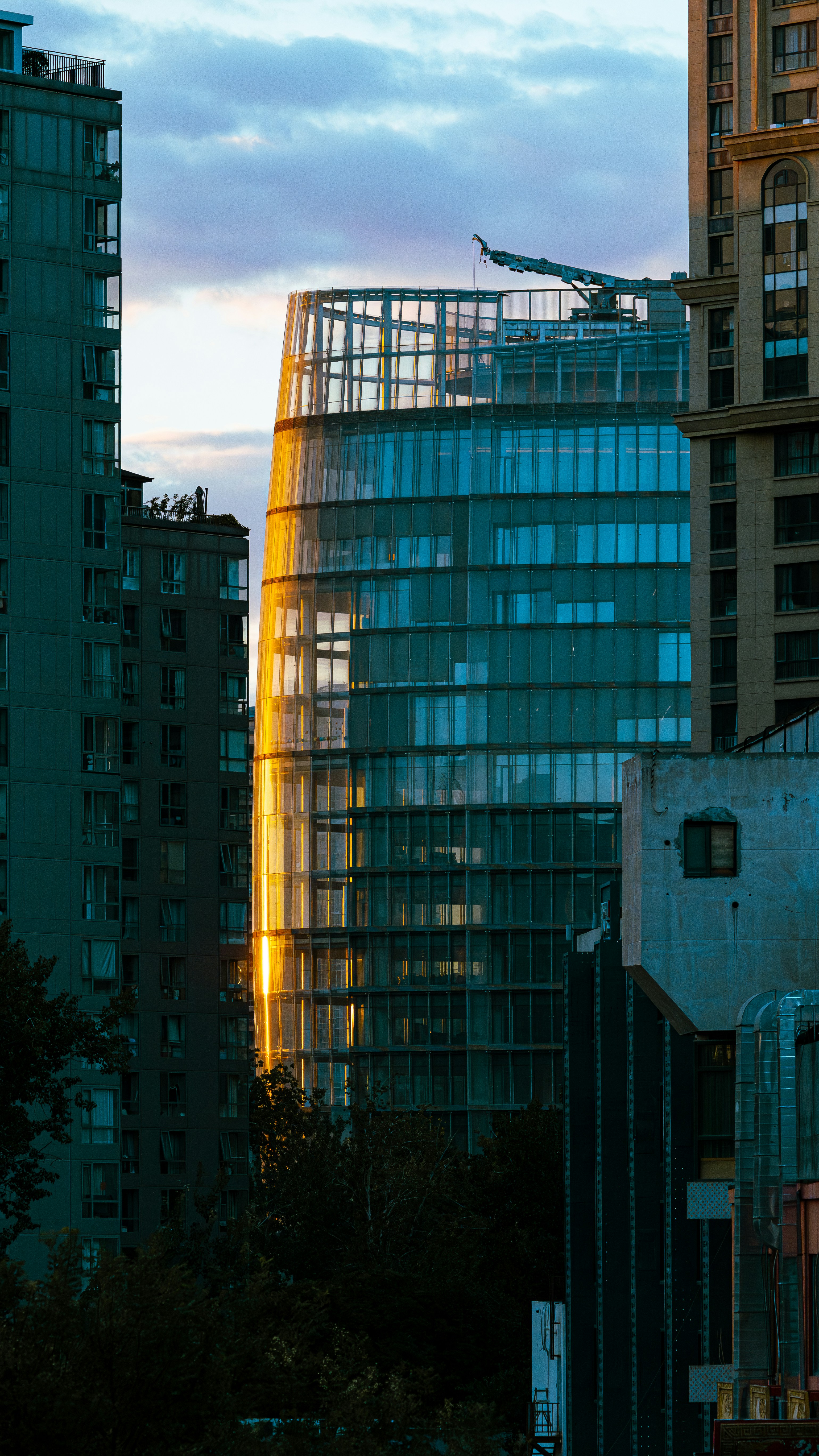 Golden Curve: Sunset Light Traces the Glass Facade of a Modern City Tower