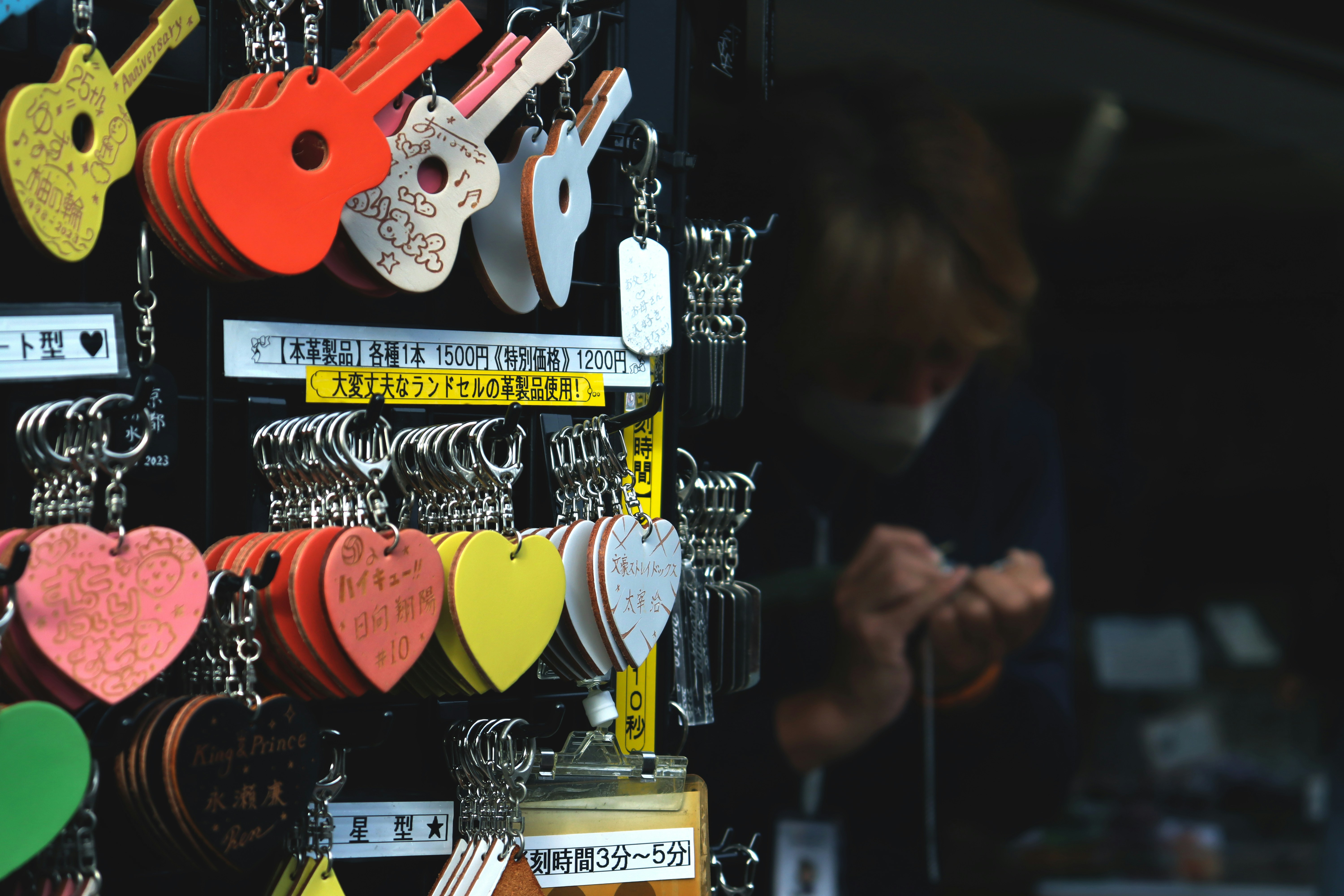 A man standing in front of a display of key chains photo – Free Person ...