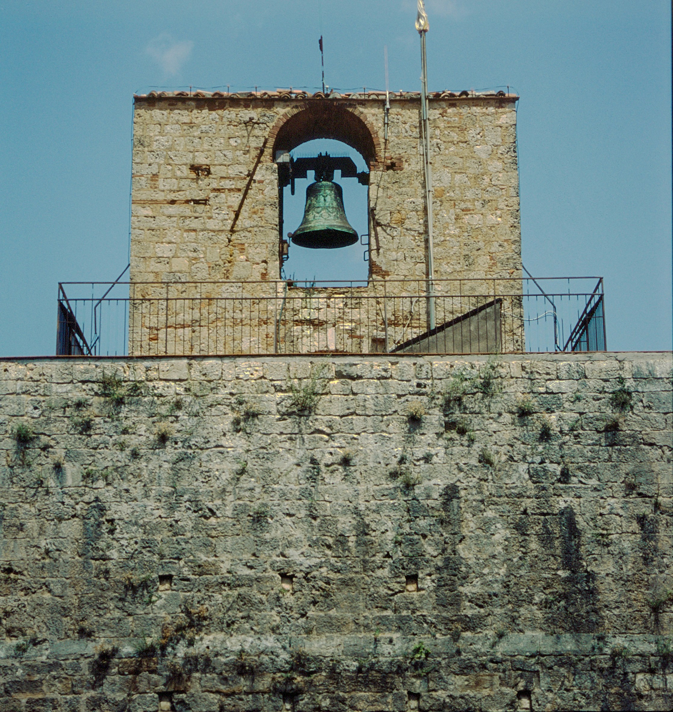 Bell in the Arch: Weathered Tower Rising Over a Stone Seawall