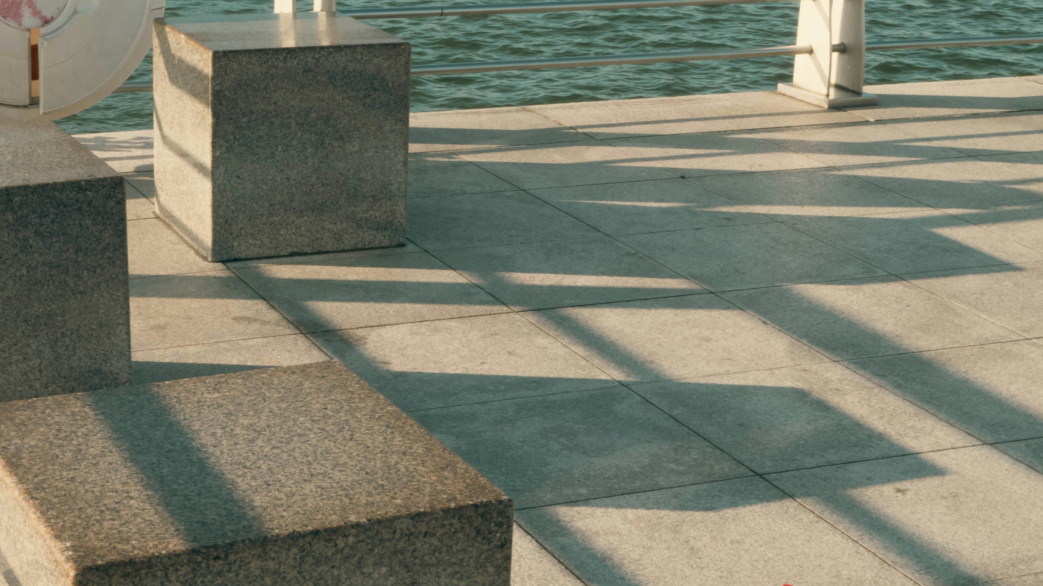 A couple of cement blocks sitting next to a body of water photo – Free ...