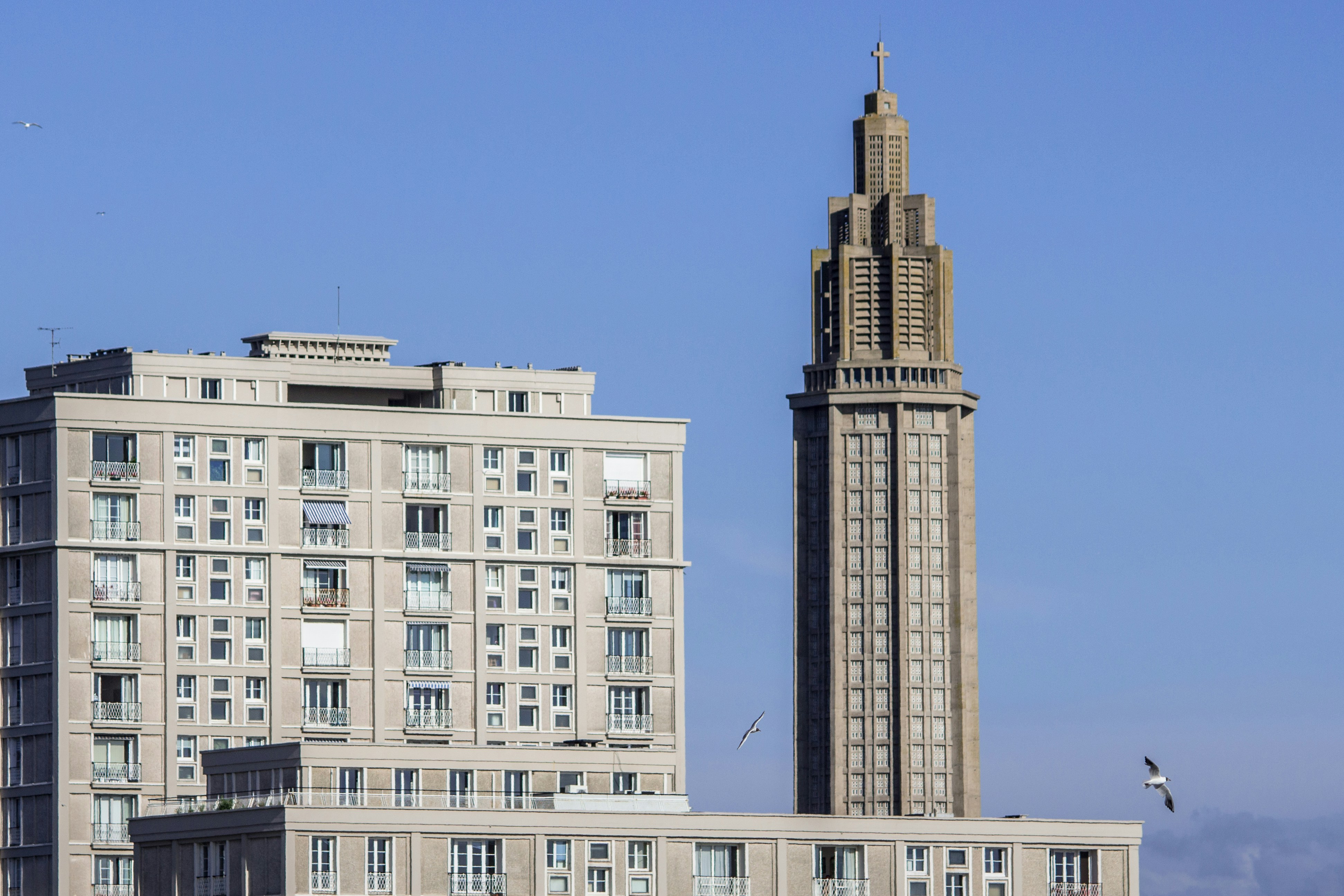 Tall building with a clock tower against a clear blue sky.