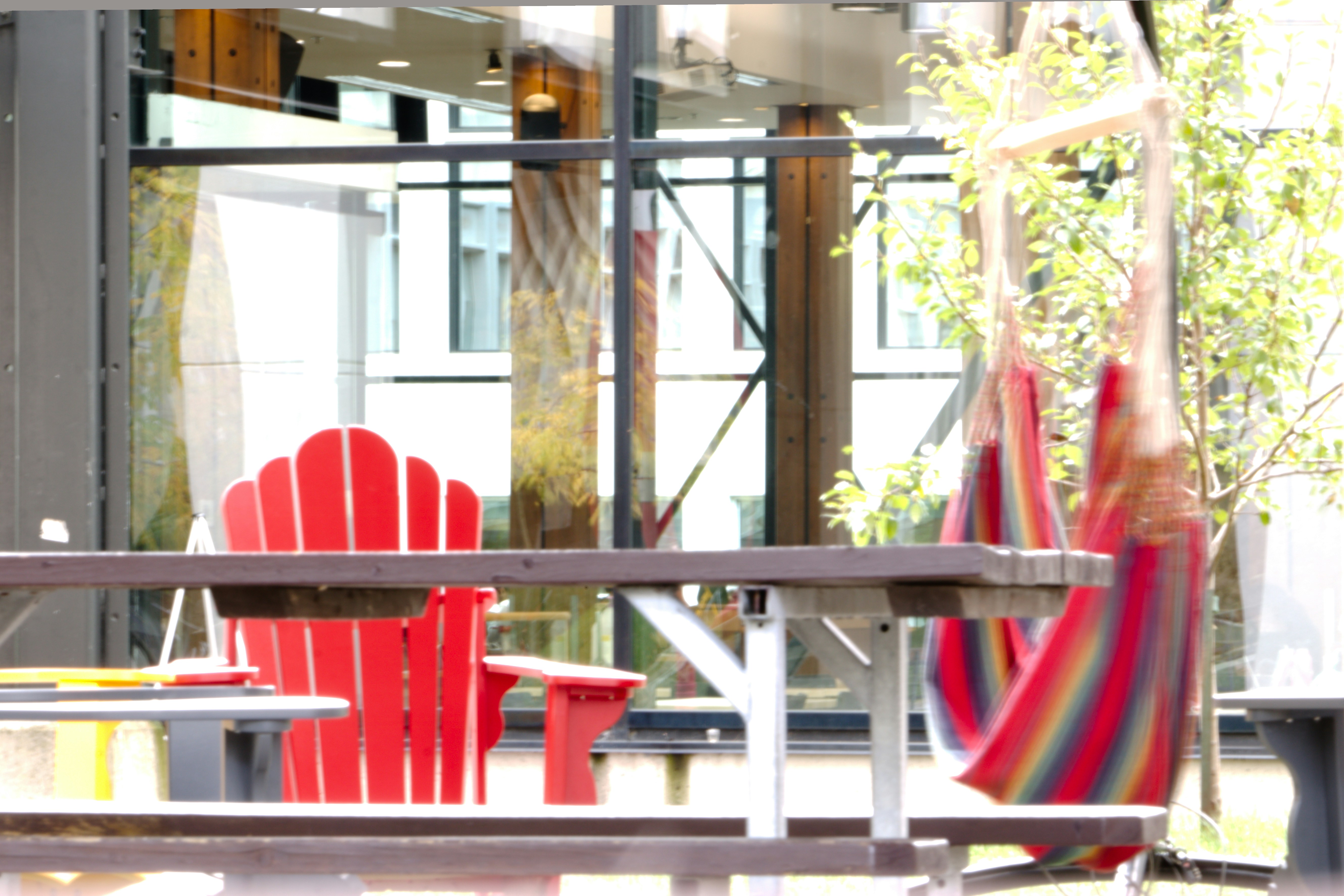 Crimson Adirondack in a Glass-Walled Courtyard: A Quiet Patio Moment