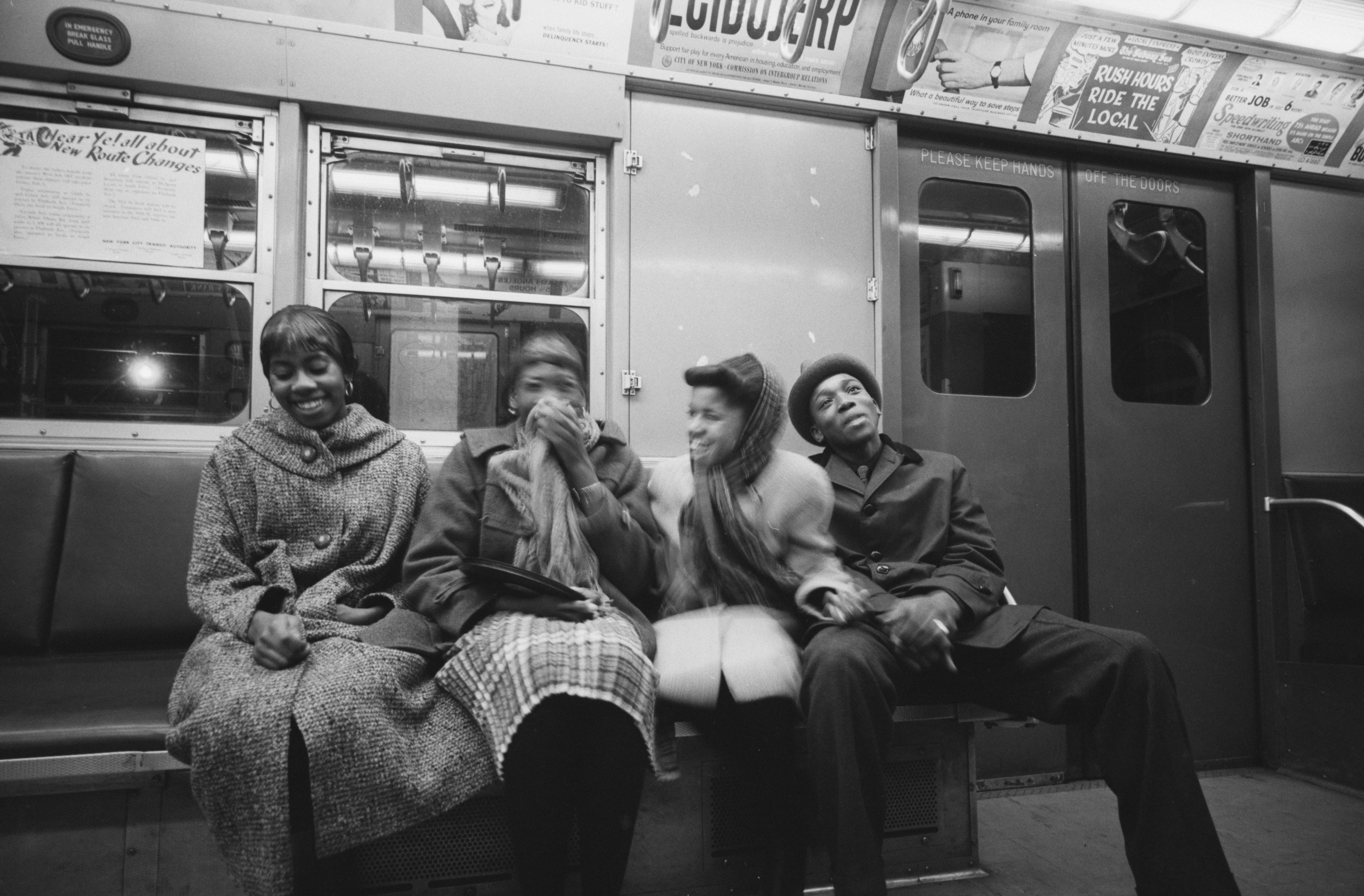 African American young people sharing a laugh while riding the subway ...
