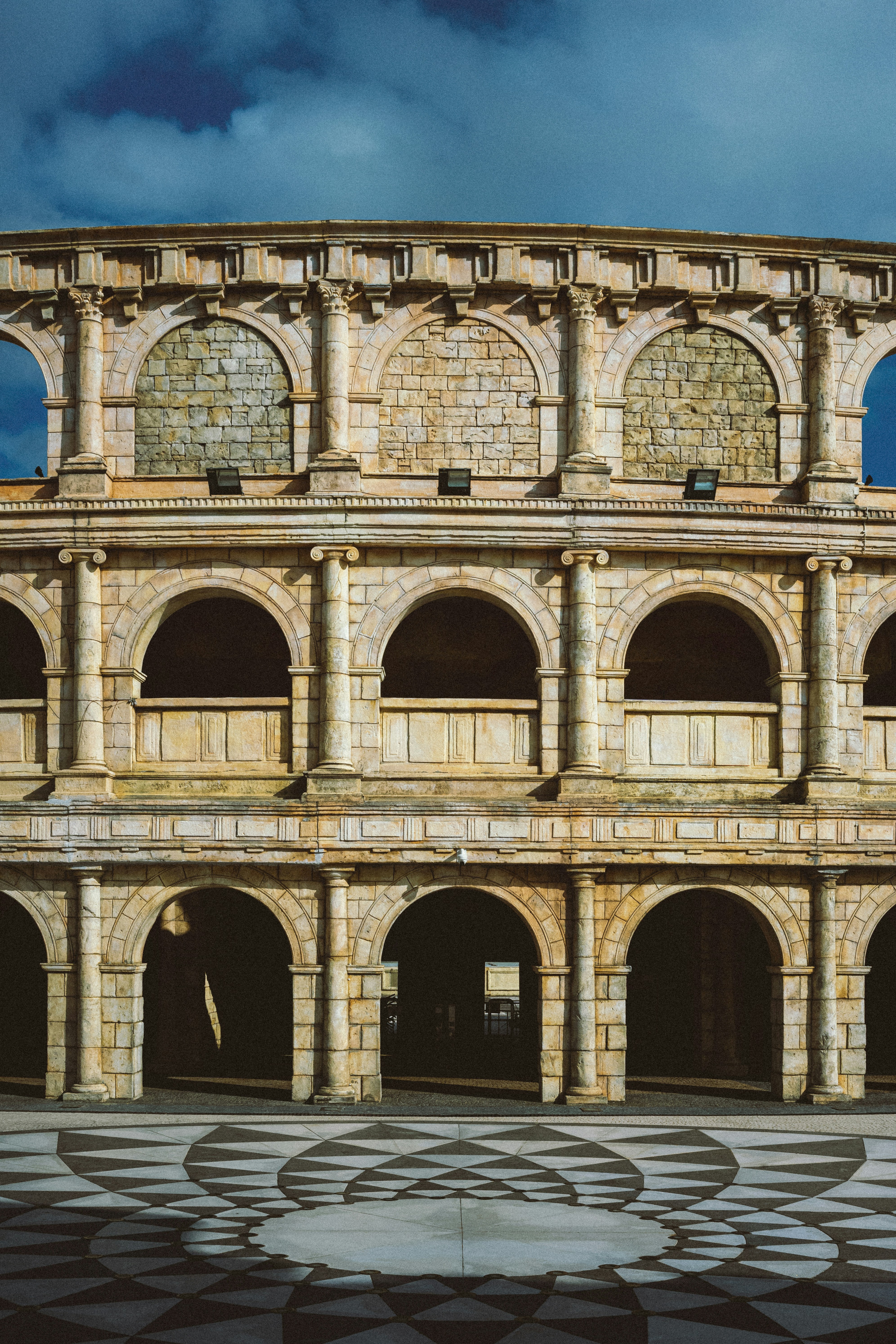 Symmetrical Arches and Circles: A Sunlit Stone Colonnade