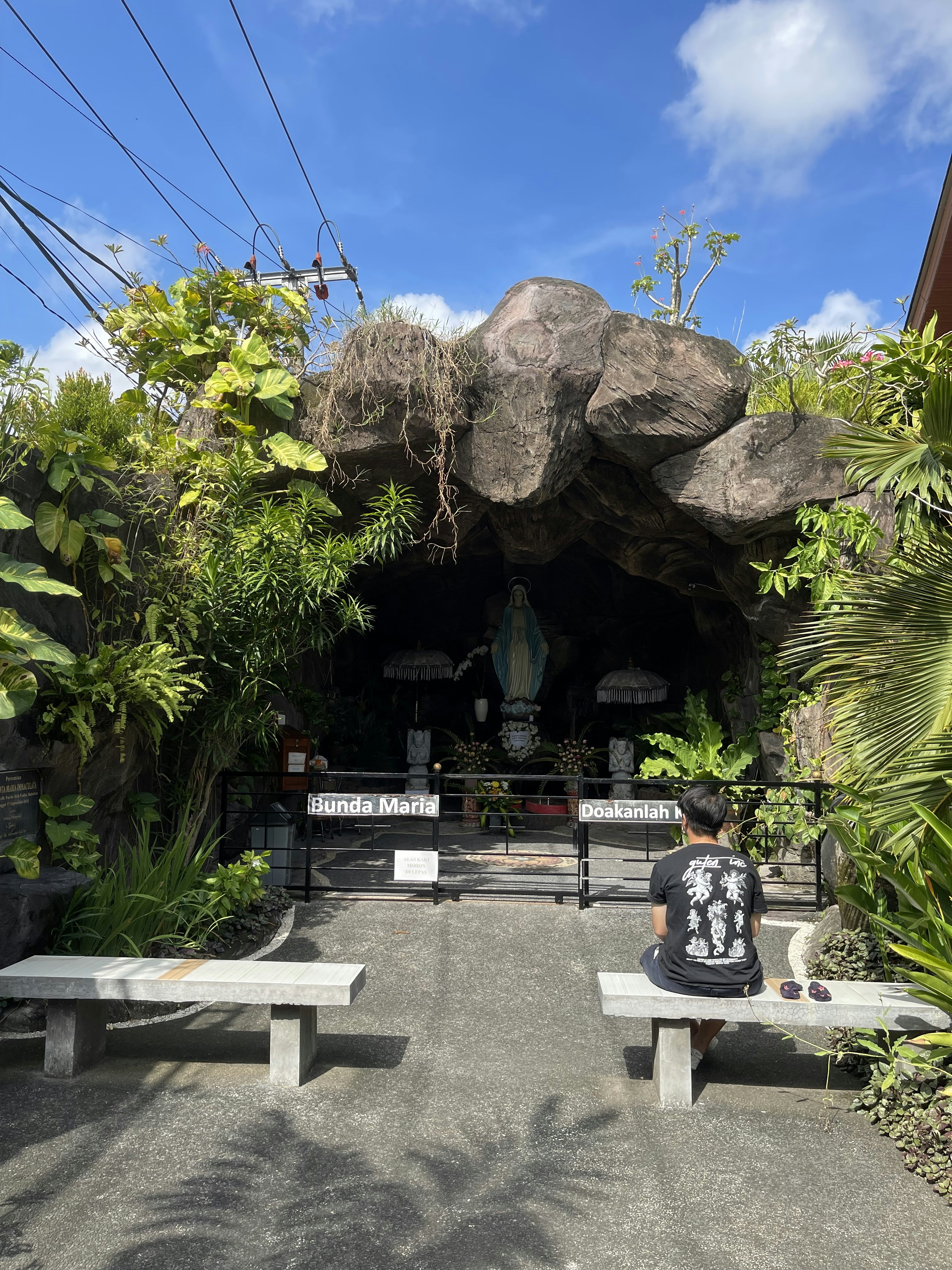 A person sitting on a bench in front of a cave photo – Free Bench Image ...