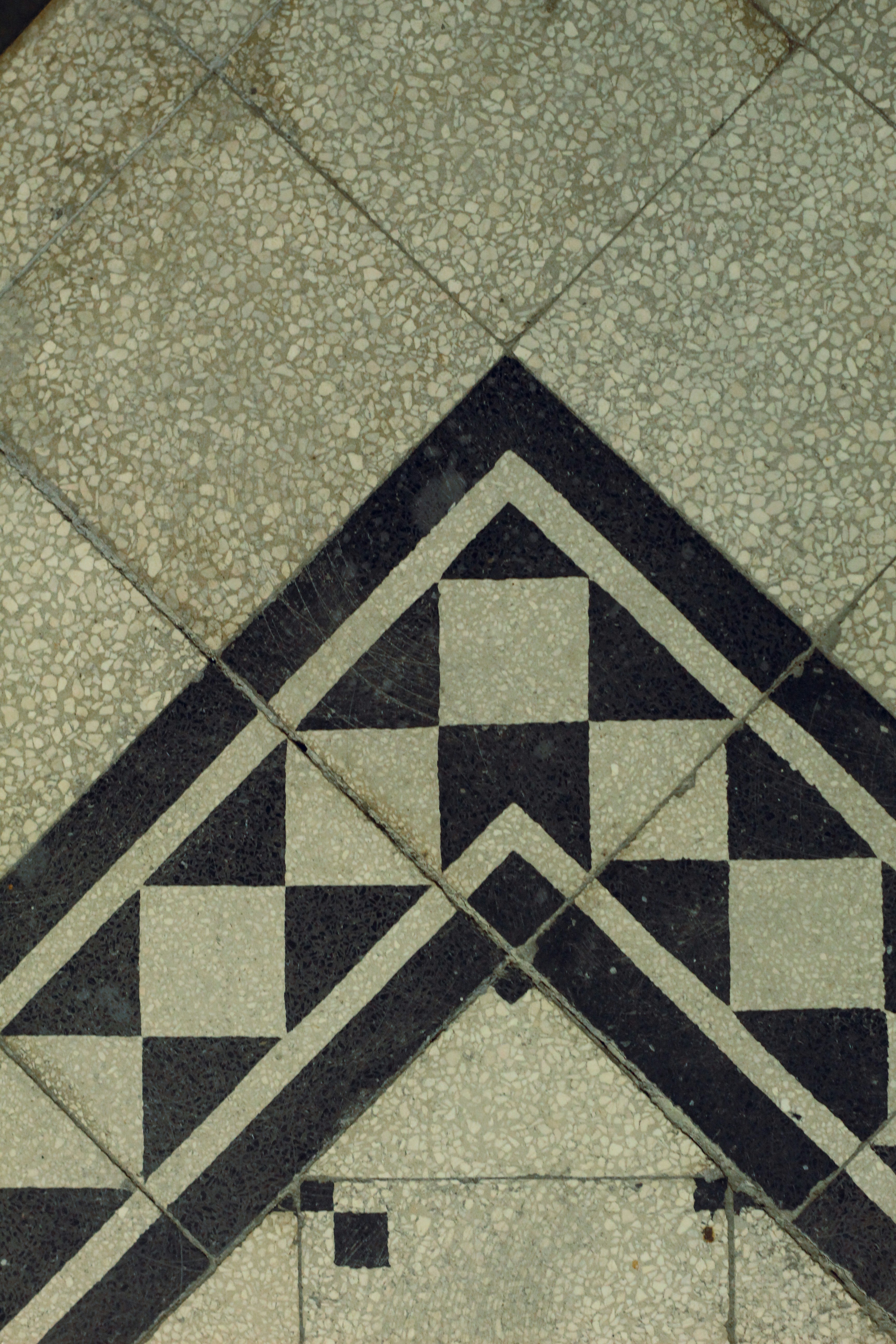 Center Diamond Meld: Interlocking chevron tessellation on a terrazzo floor