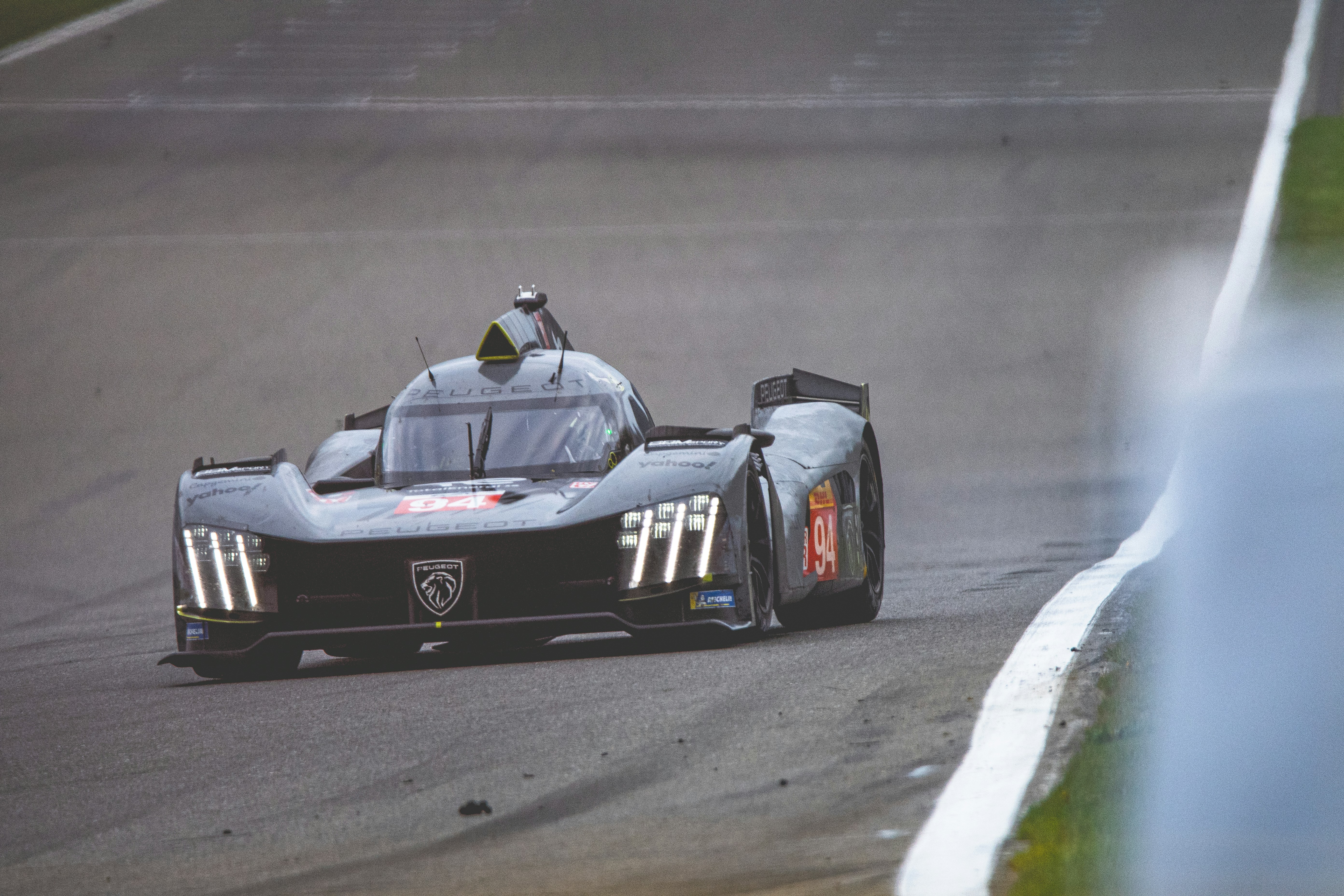 A race car driving on a race track photo – Free Race car Image on Unsplash