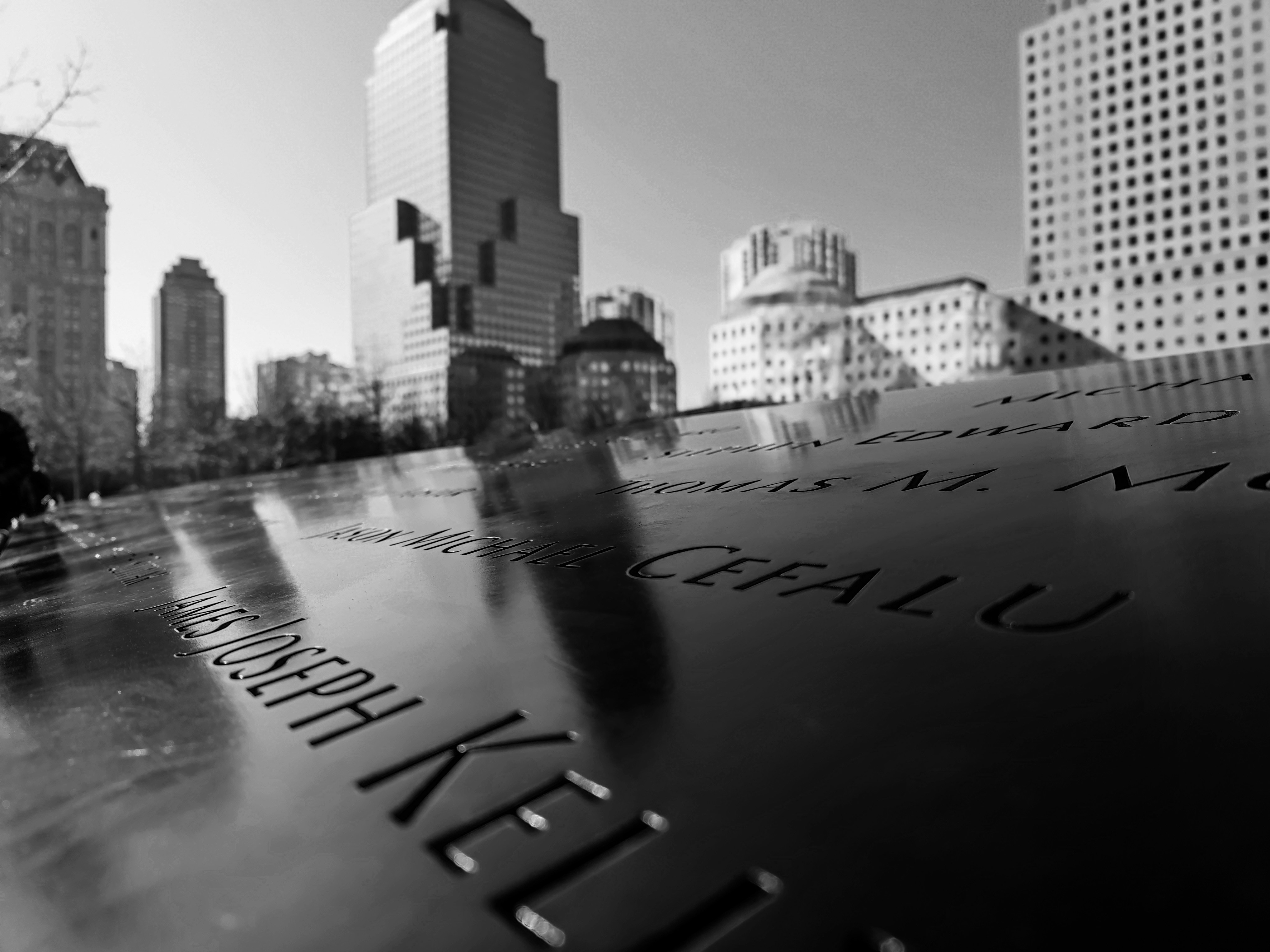 Names in the Glassy Plane: Cityscape Reflections Across a Memorial Panel