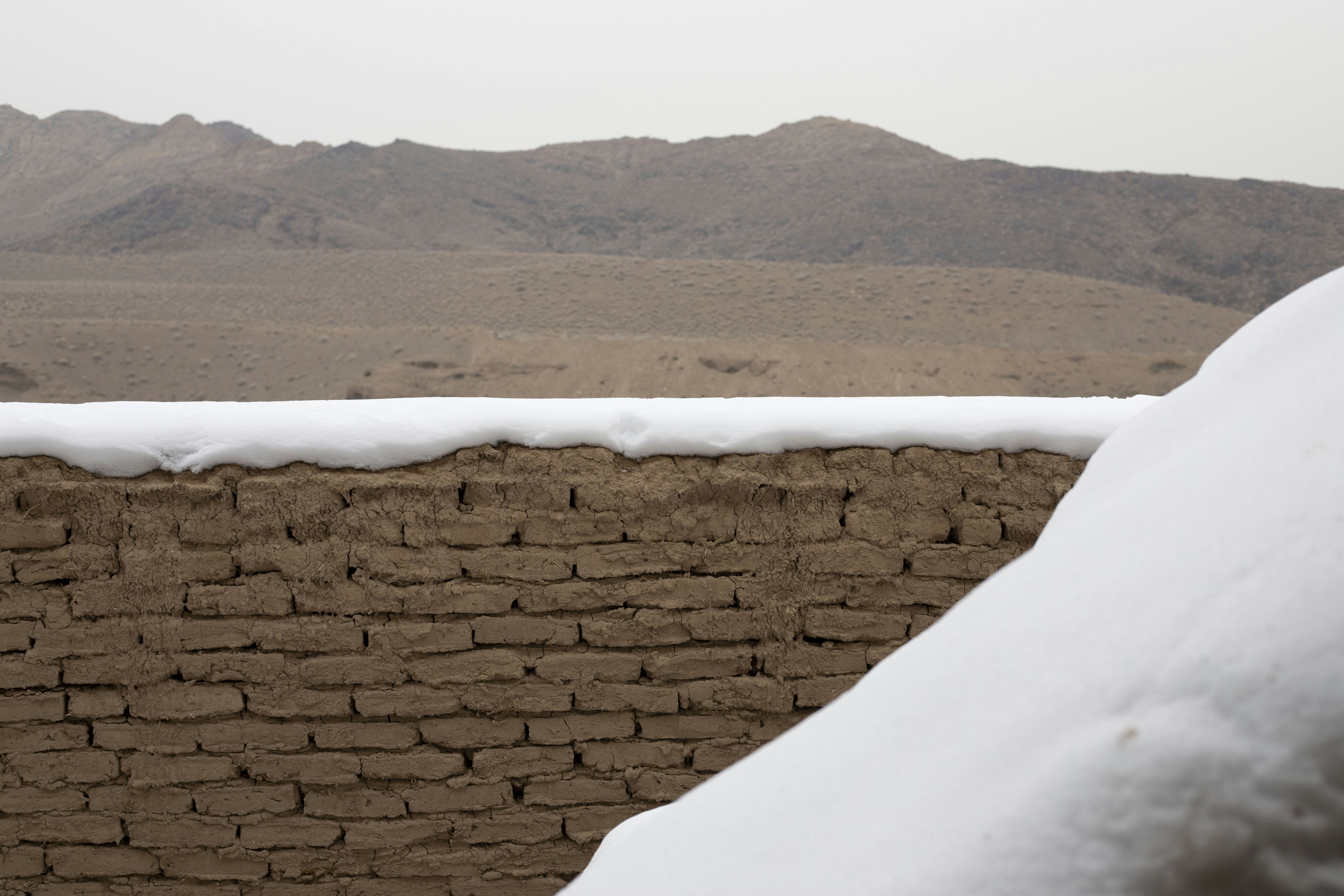 Snow-Capped Edge: A Desert Wall Meets Winter Veil