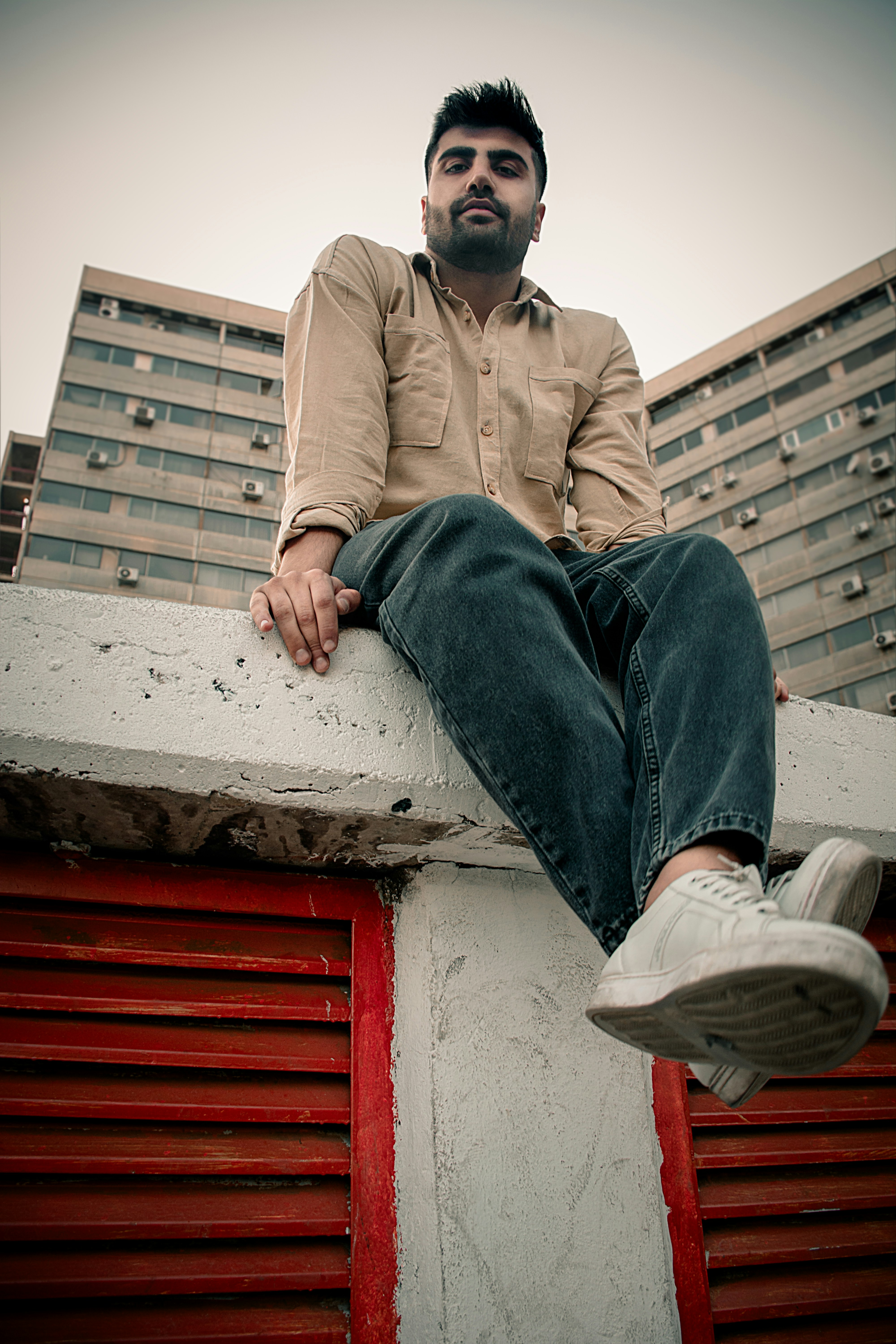 A man sitting on a ledge with his legs crossed photo – Free Iran Image ...