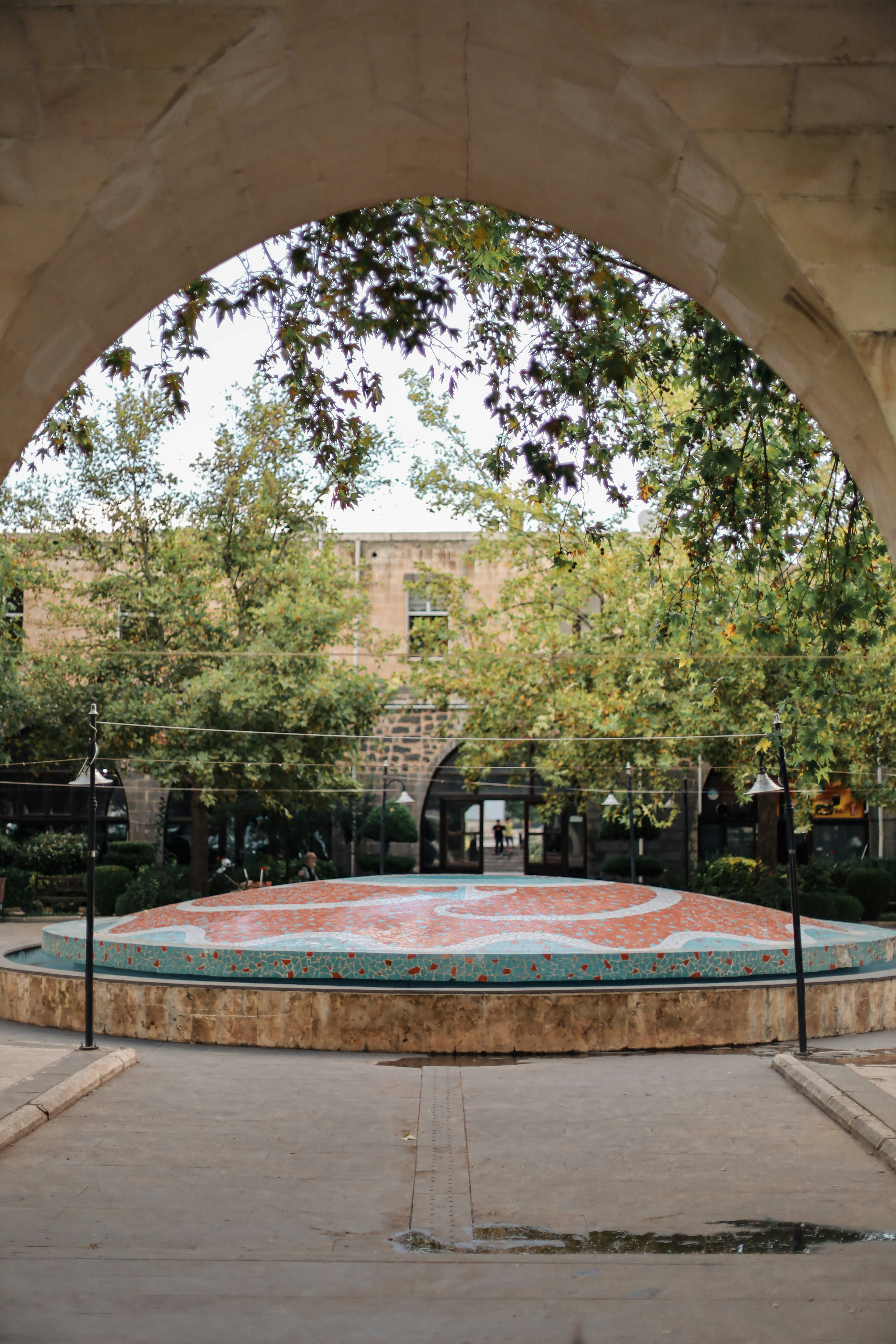 A circular fountain surrounded by trees in a courtyard photo – Free ...