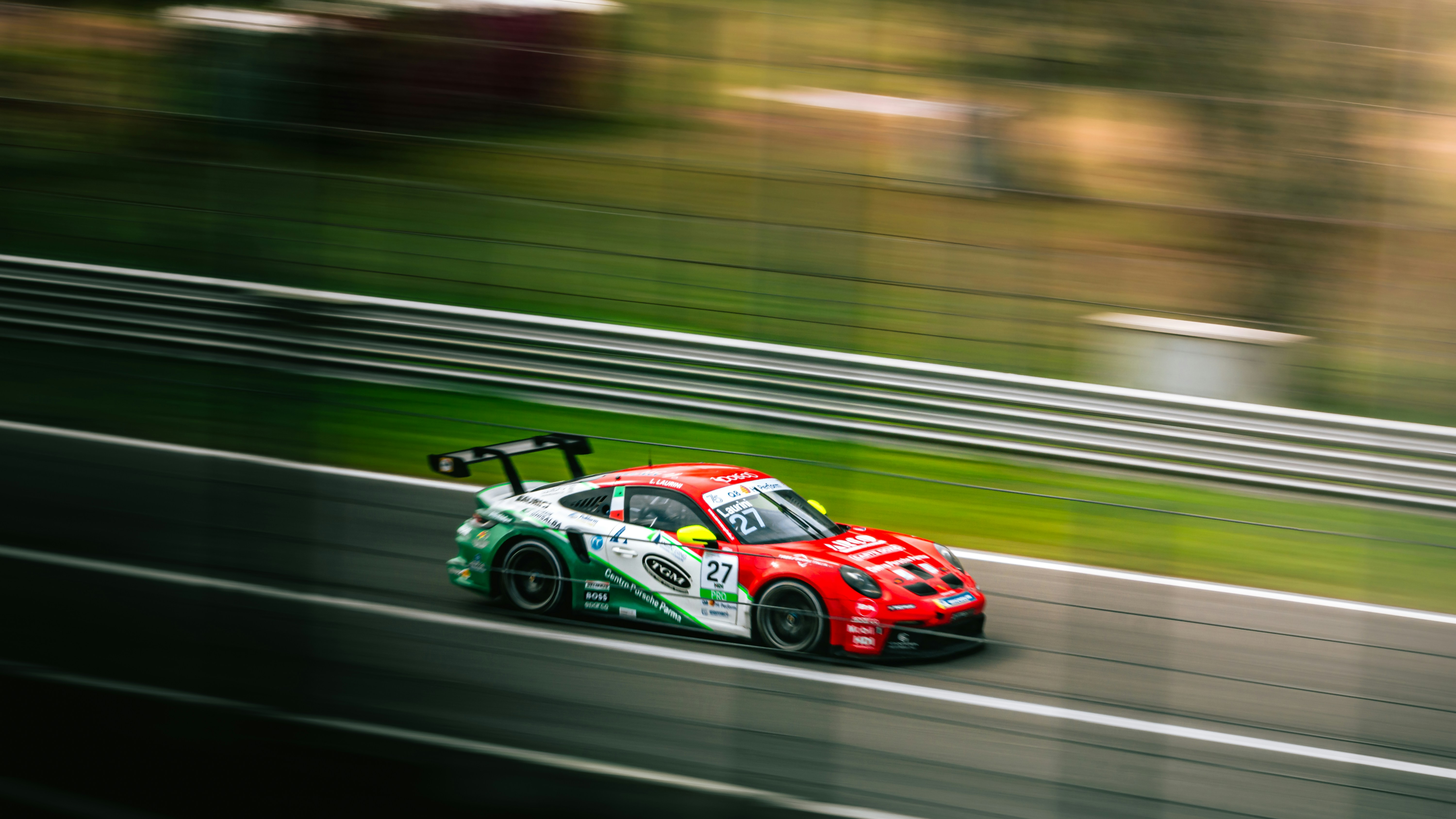 A red and green car driving down a race track photo – Free Car Image on ...