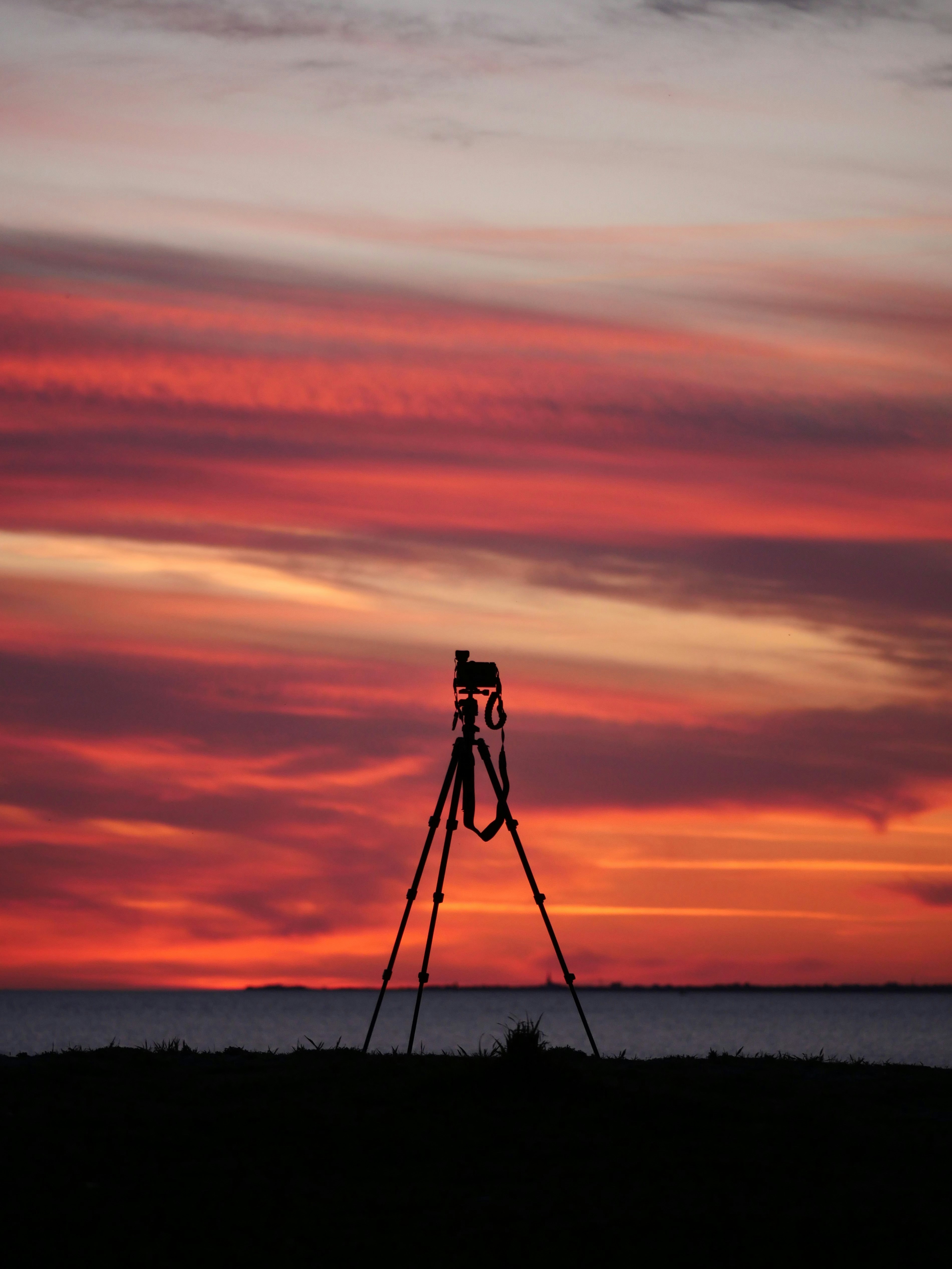 Fiery Dusk: Tripod Sentinel Against a Painted Sky
