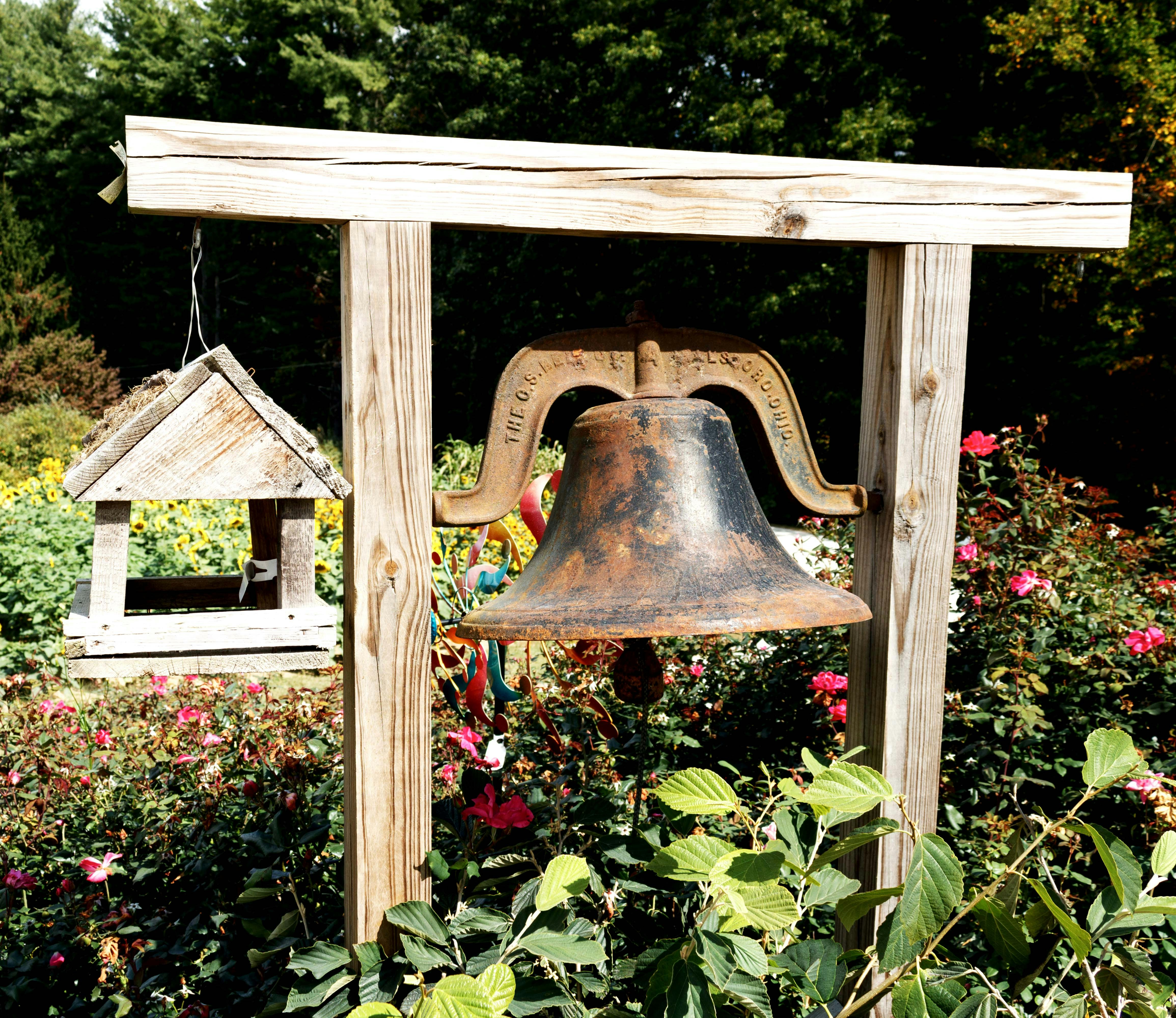 Eine Glocke, die an einer Holzkonstruktion in einem Garten hängt Foto ...