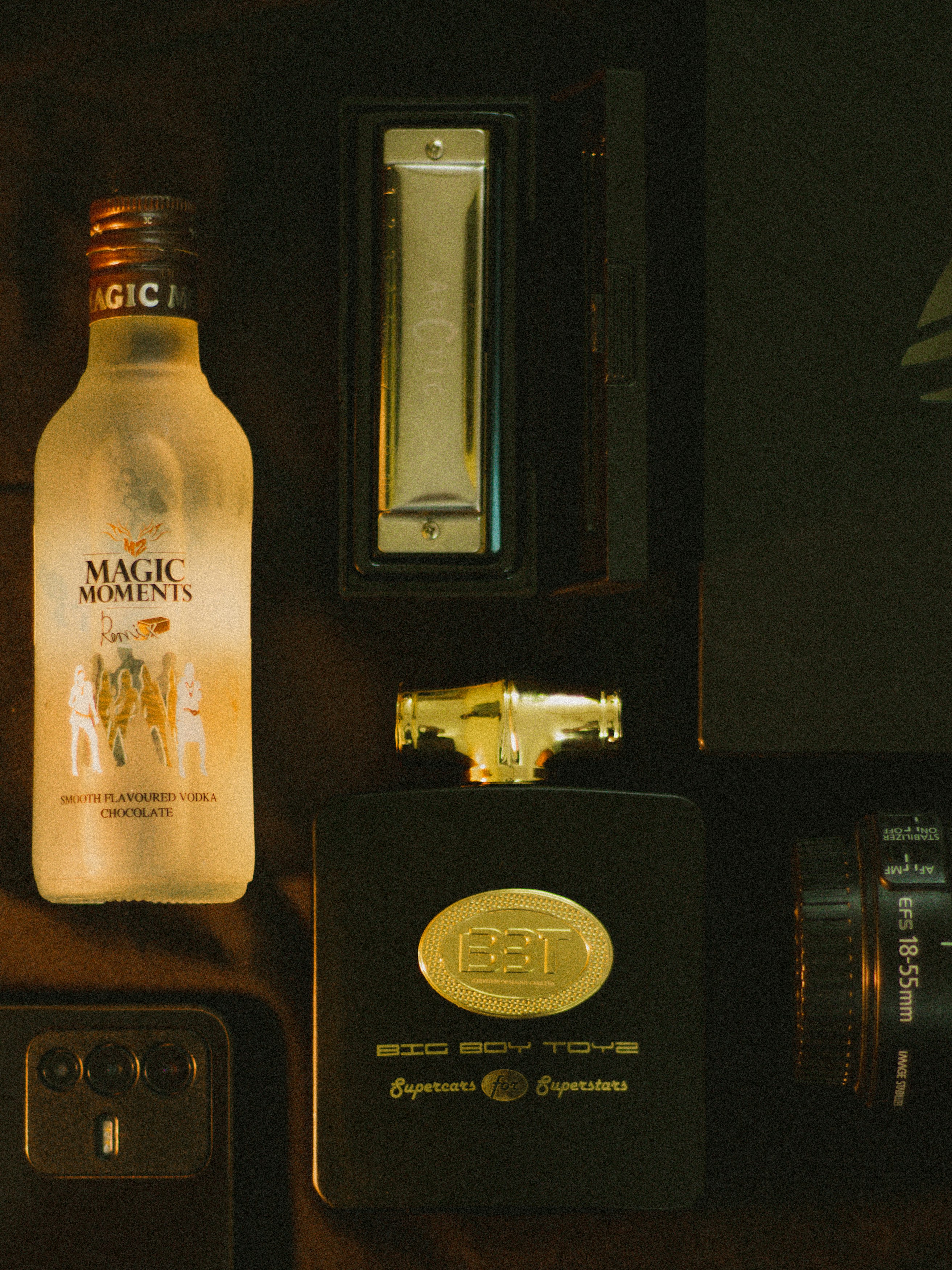 A bottle of alcohol next to a camera and other items photo – Free ...