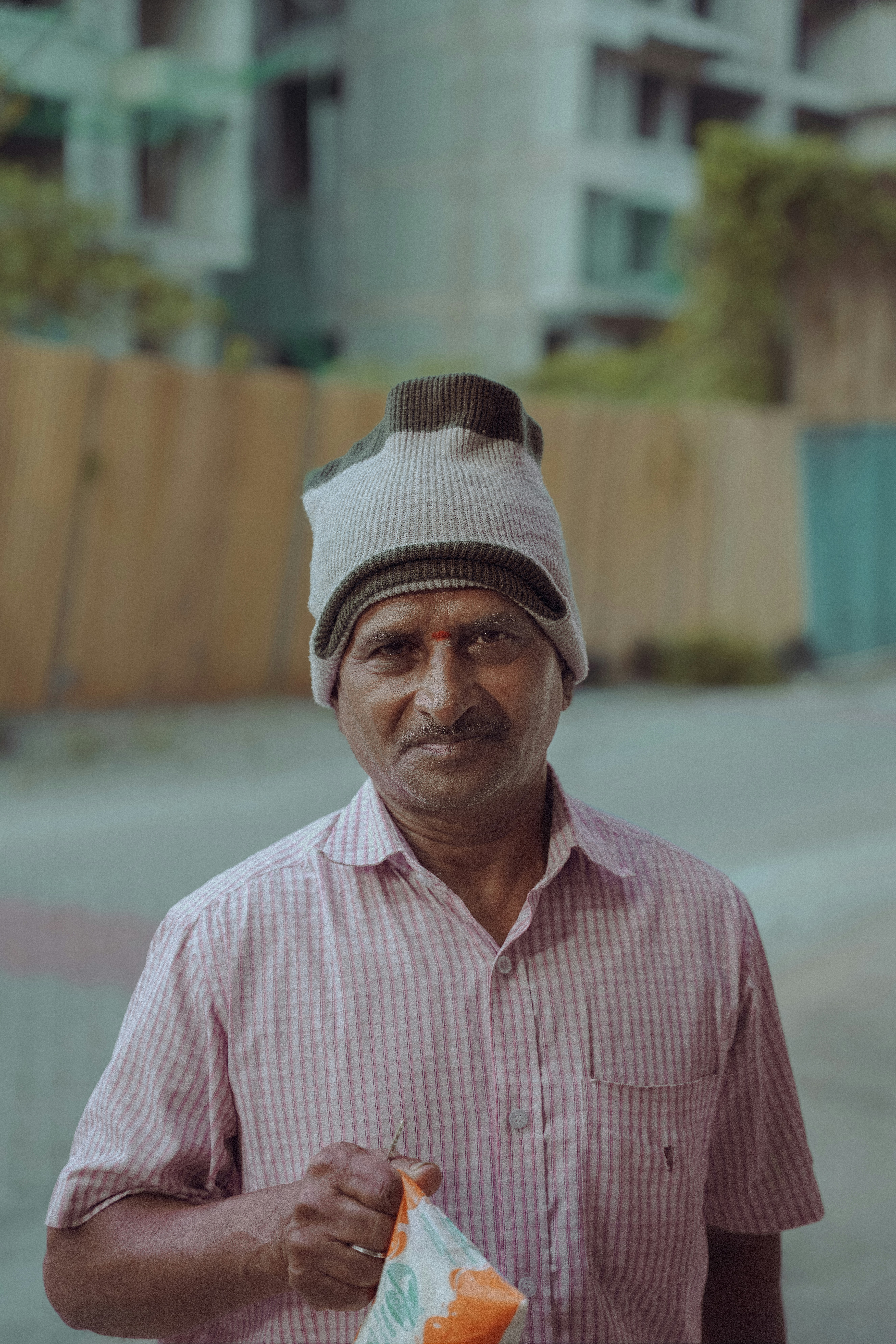 Gentle Gaze: Street Vendor Amid City Blur