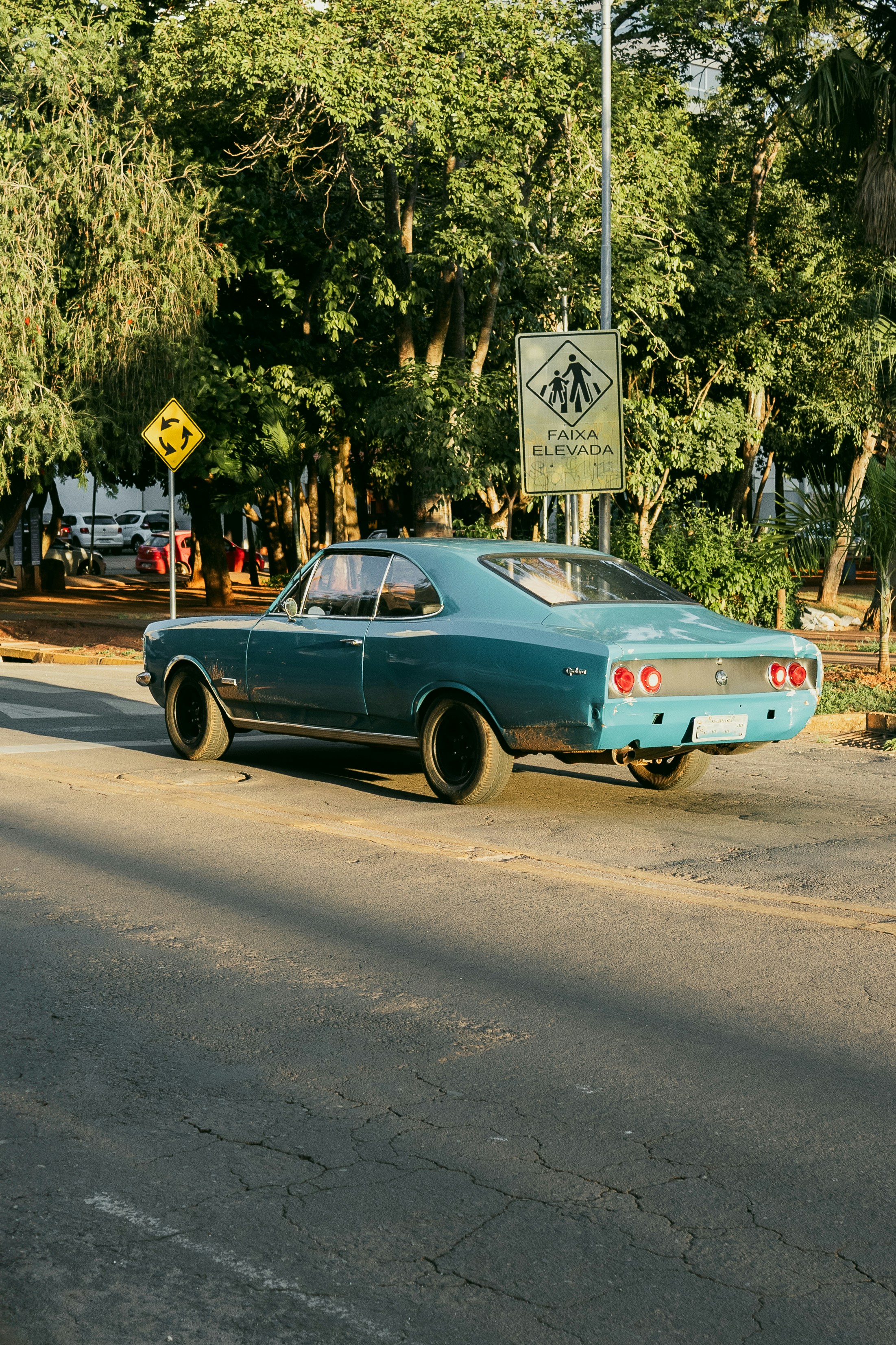 Blue 1960s Coupe at a Quiet Urban Crossing