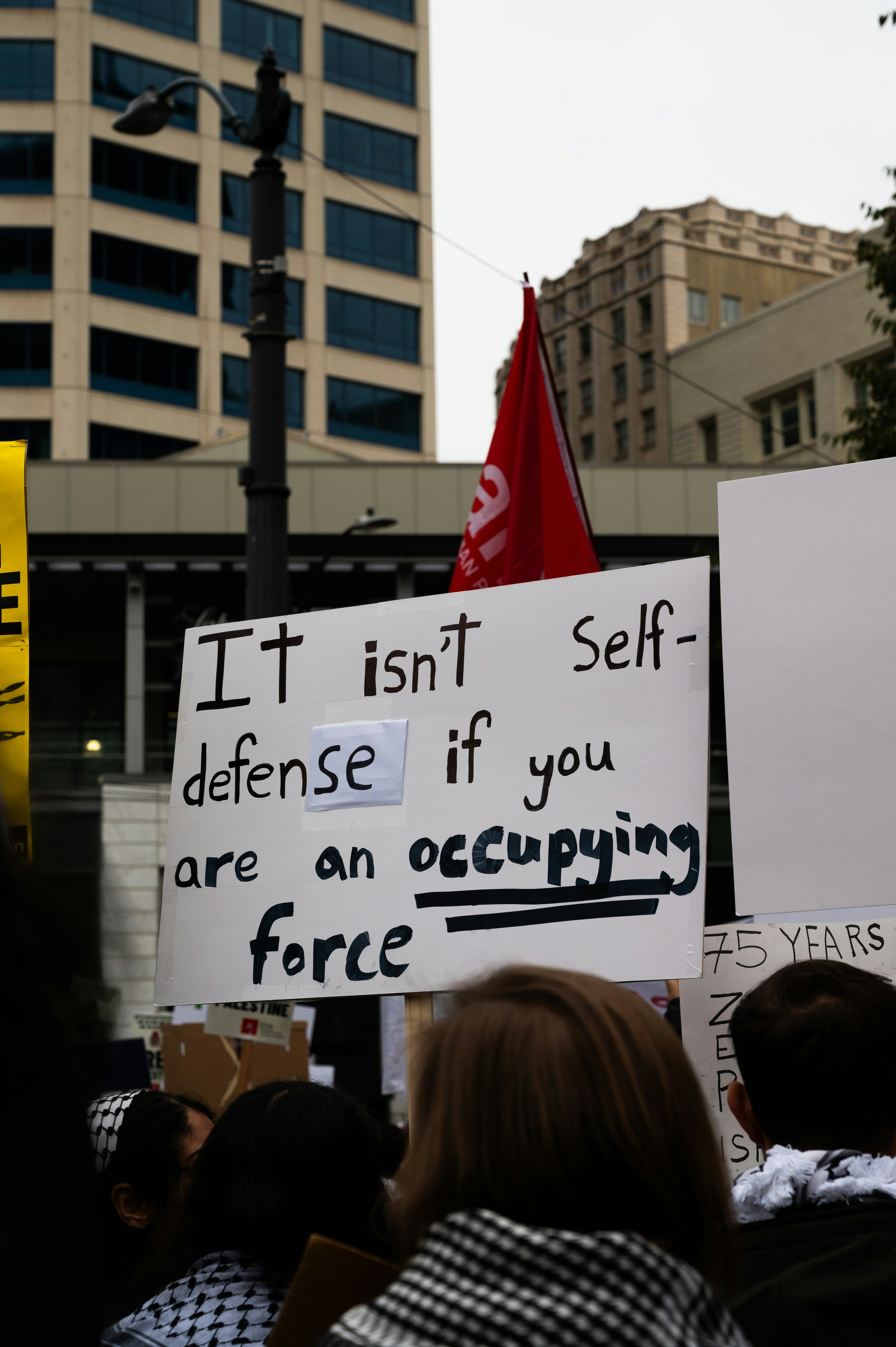 A group of people holding signs in front of a building photo – Free Wa ...