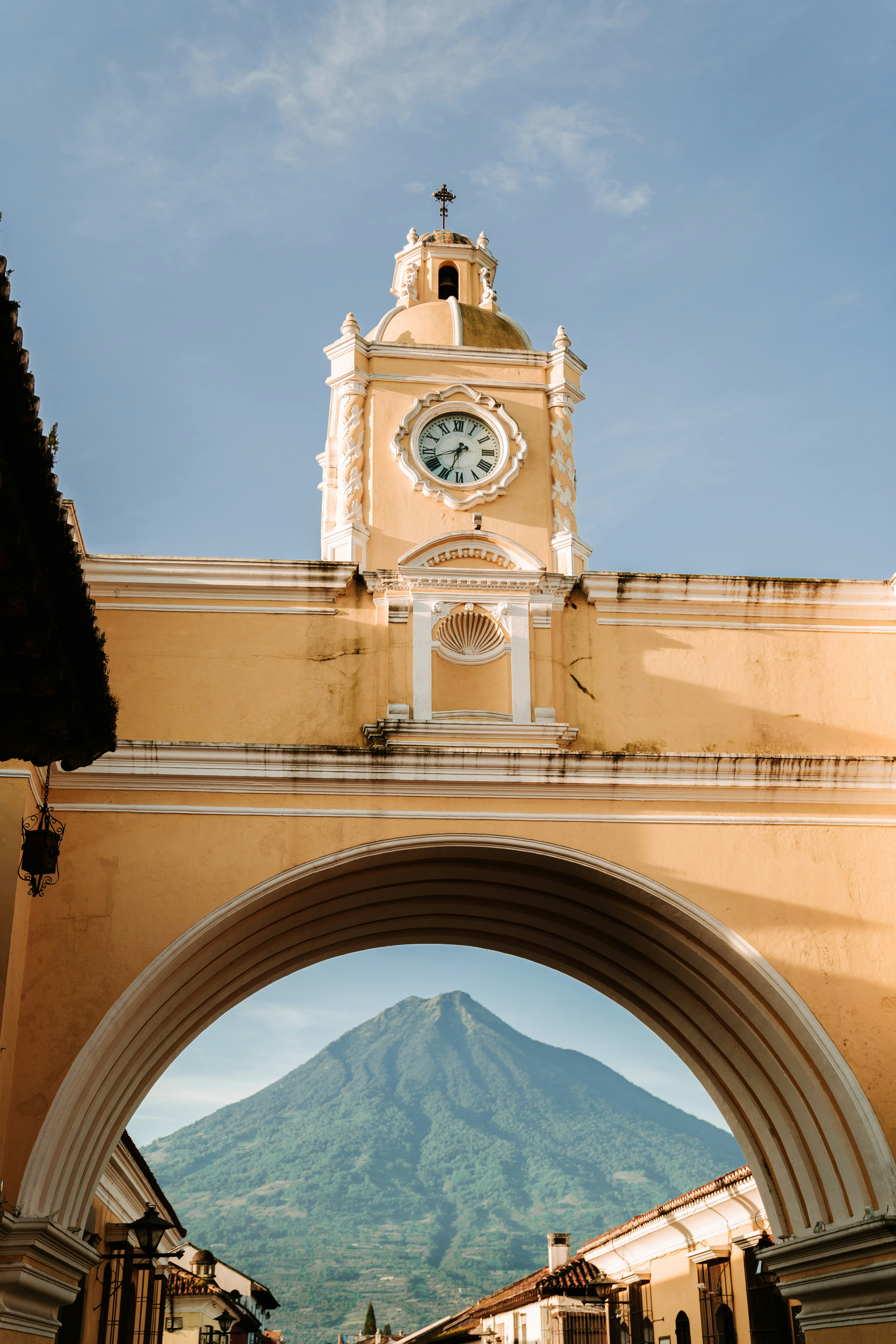 A clock tower with a mountain in the background photo – Free Volcano ...