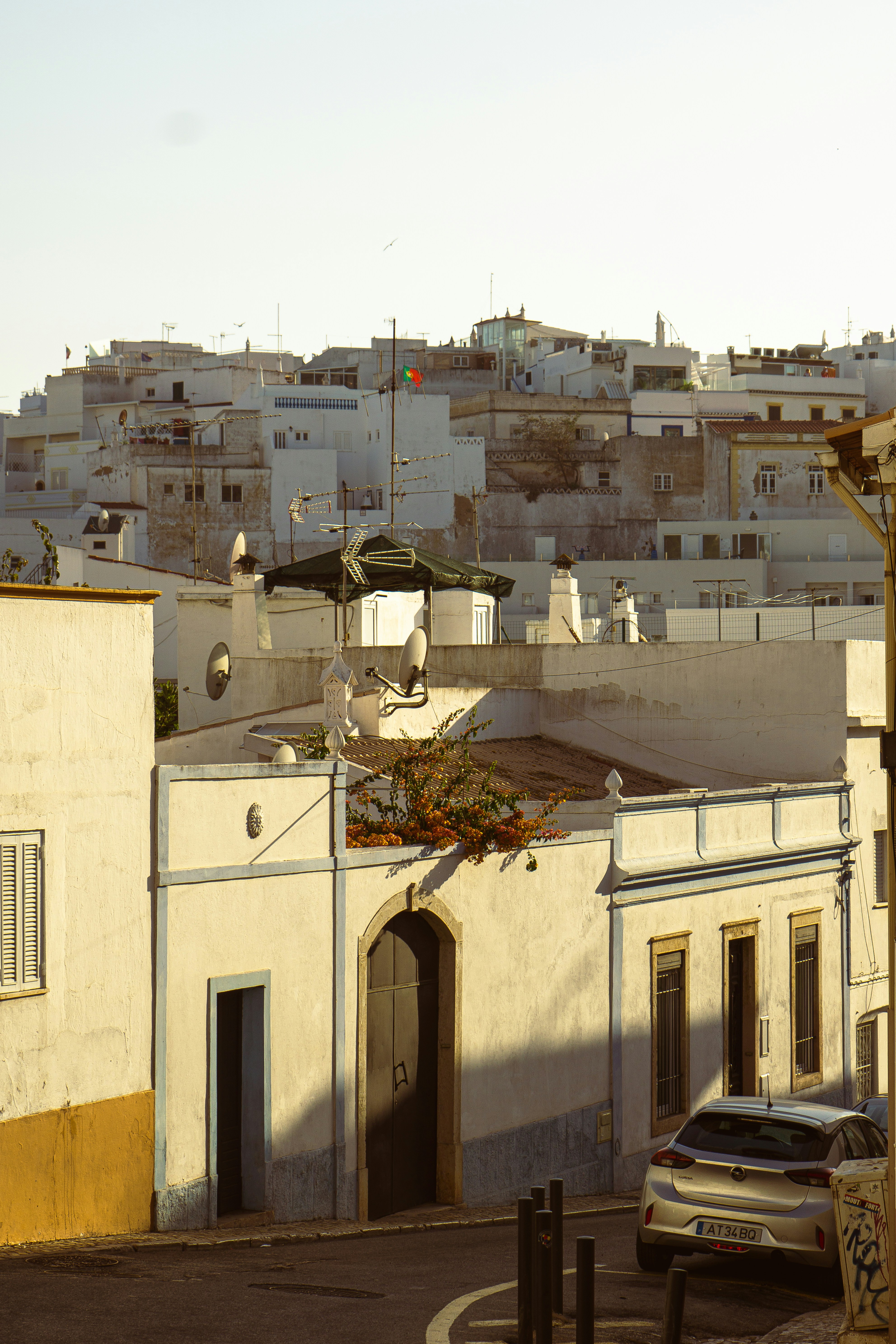 Arched Entrance Anchors a Quiet Street Among Sun-Washed Rooftops
