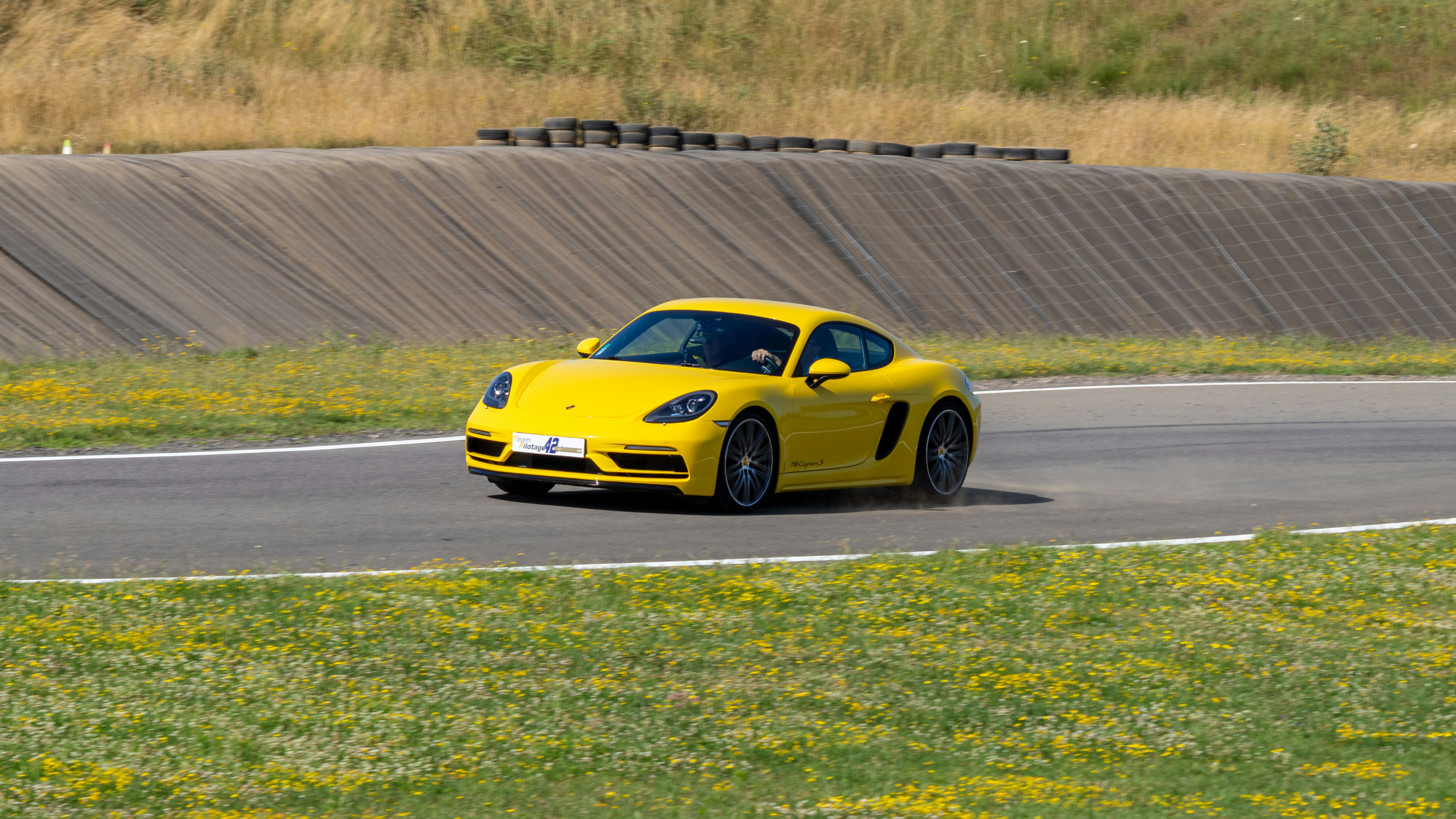 A yellow sports car driving on a race track photo – Free Team pilotage ...