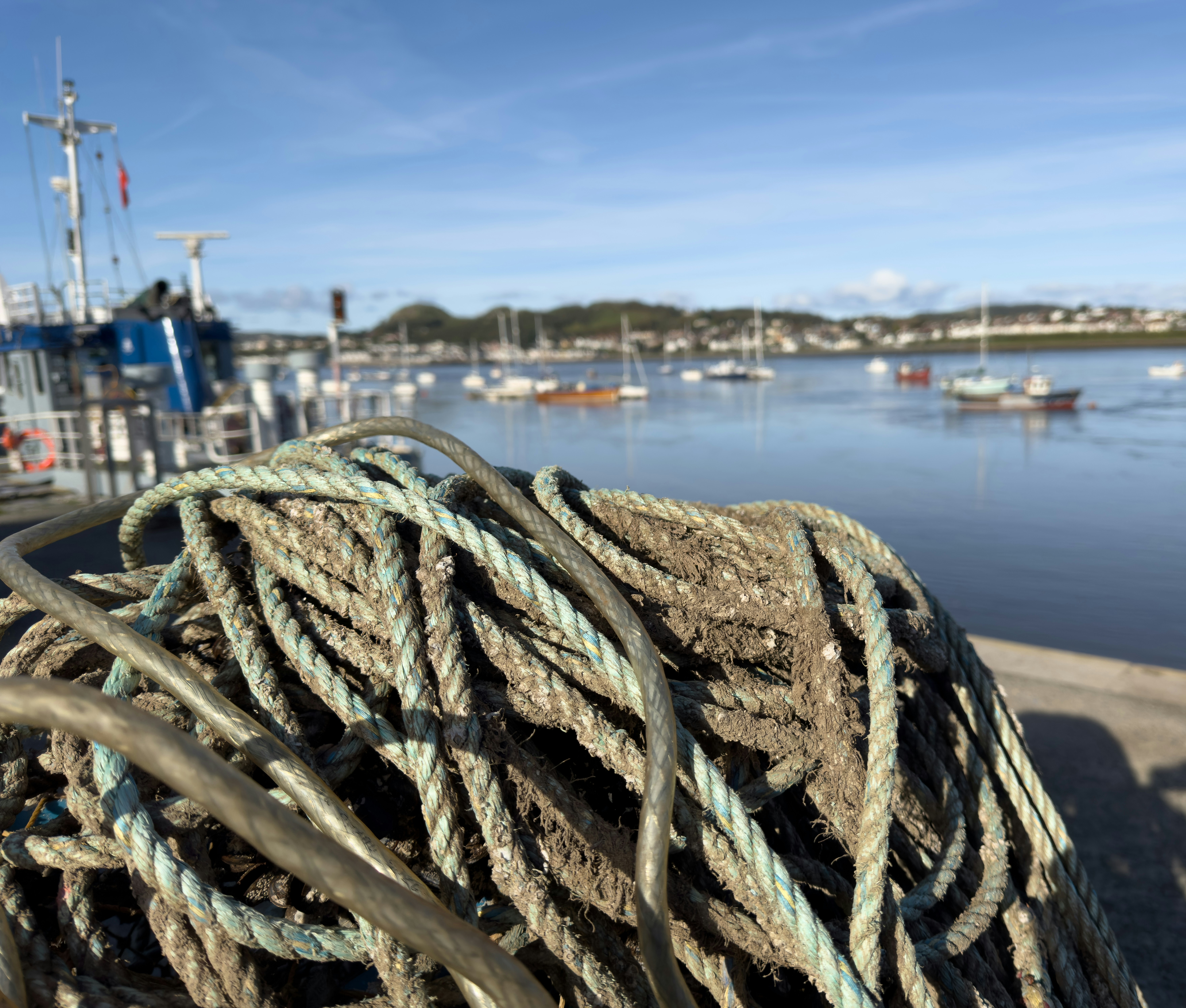 A pile of rope sitting next to a body of water photo – Free Conwy Image ...