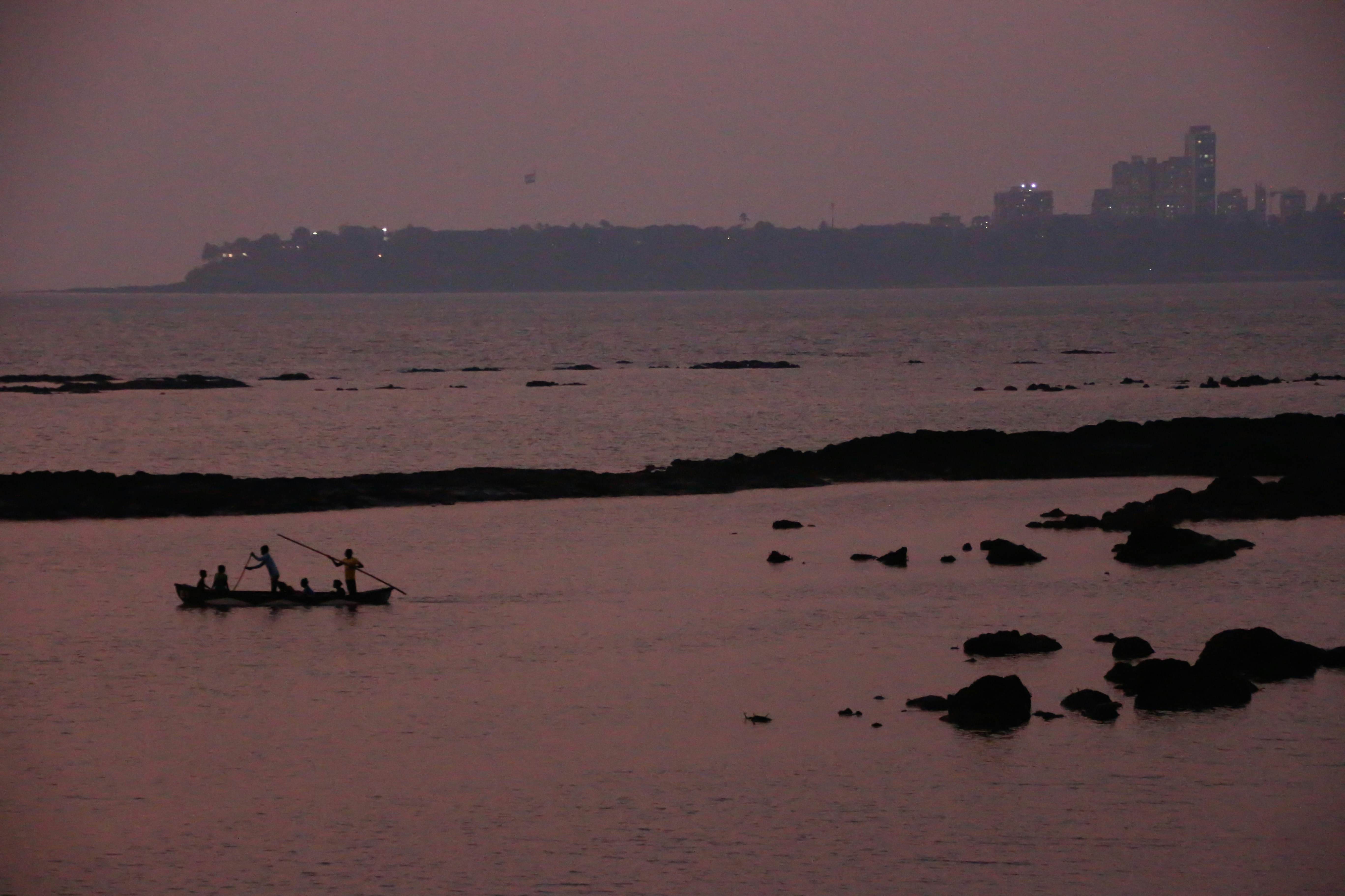 A group of children fishing on a sunset in Mumbai.