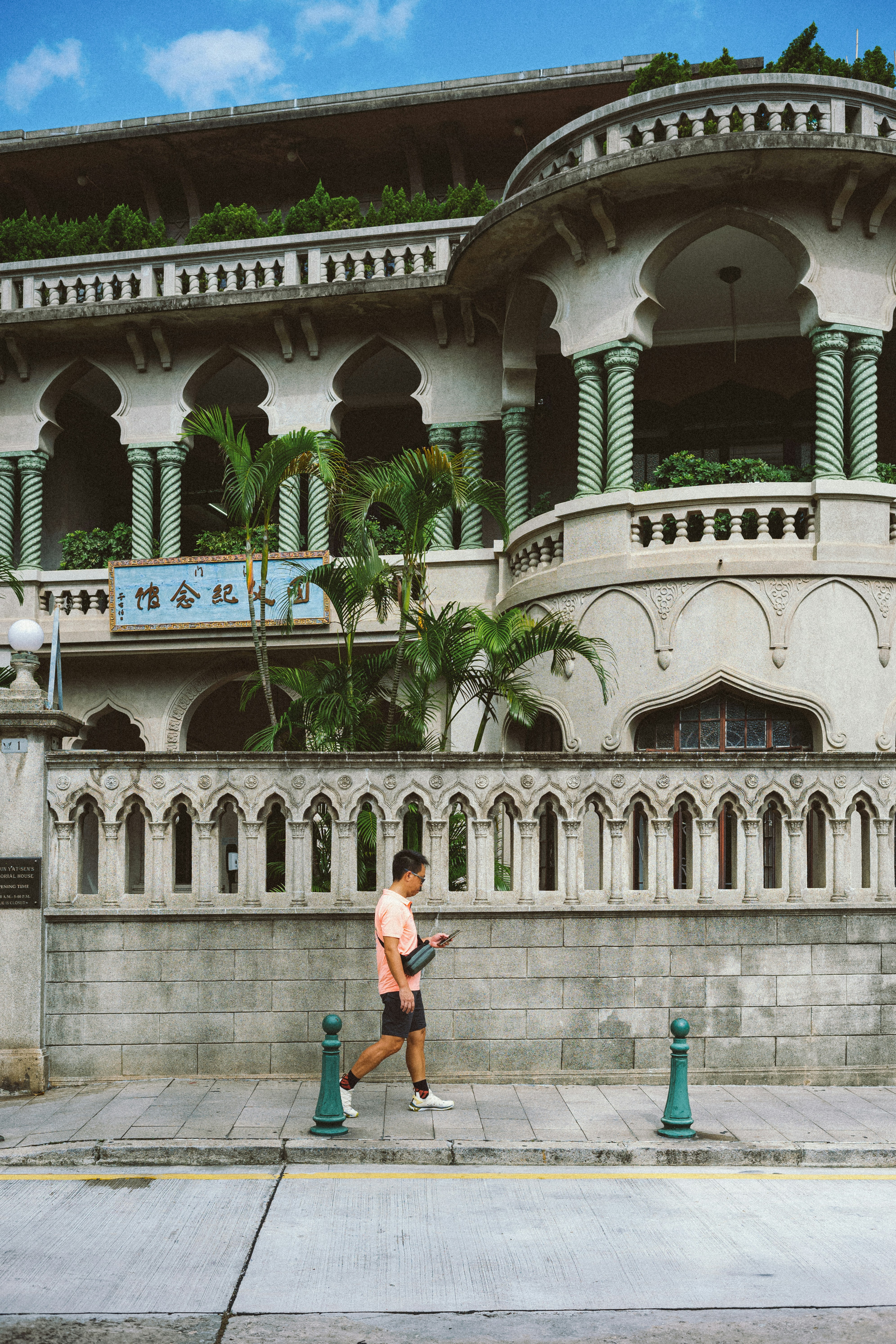 Pedestrian in front of ornate, tropical-tinged facade