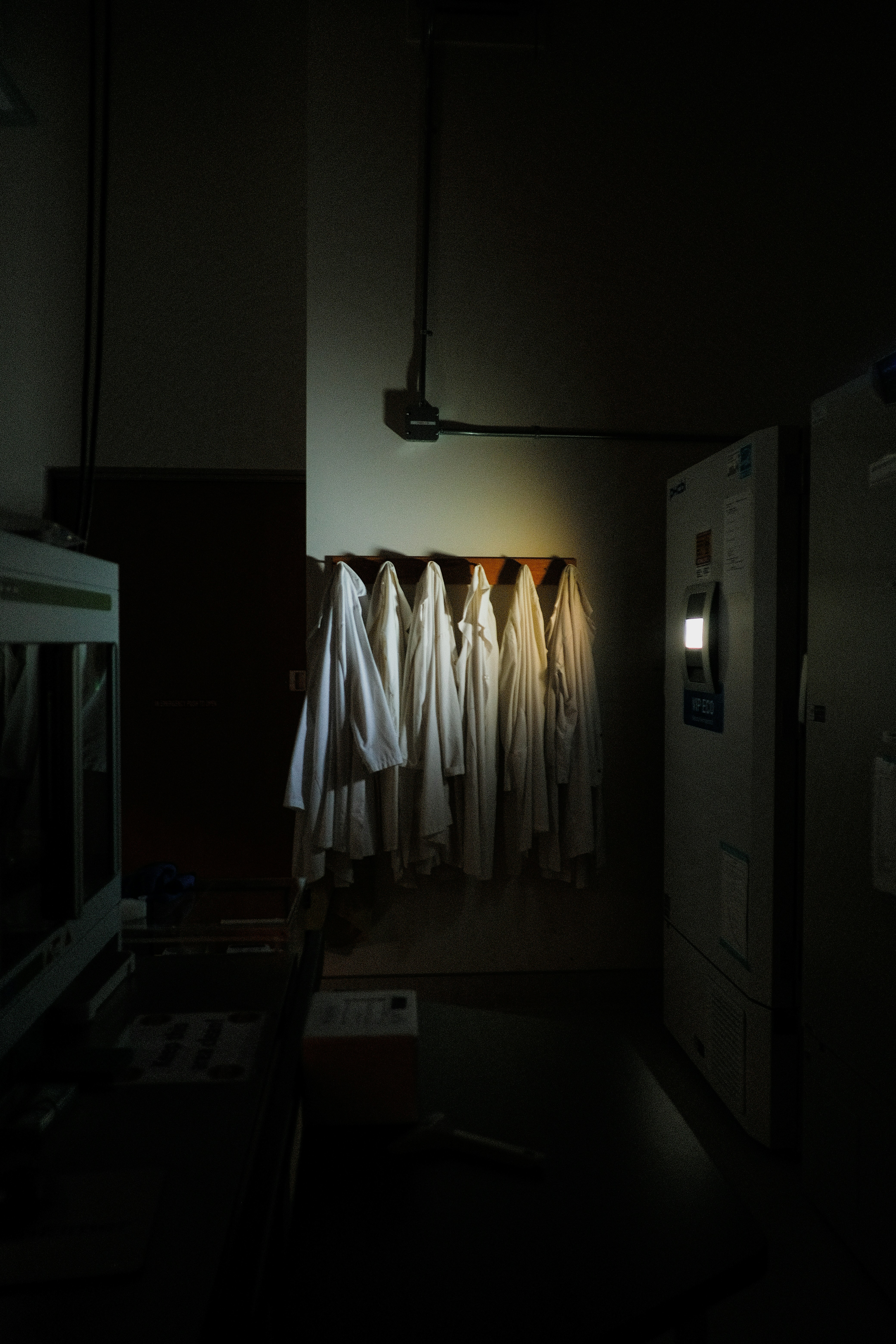 A row of white robes hanging on a wall photo – Free Lighting Image on ...