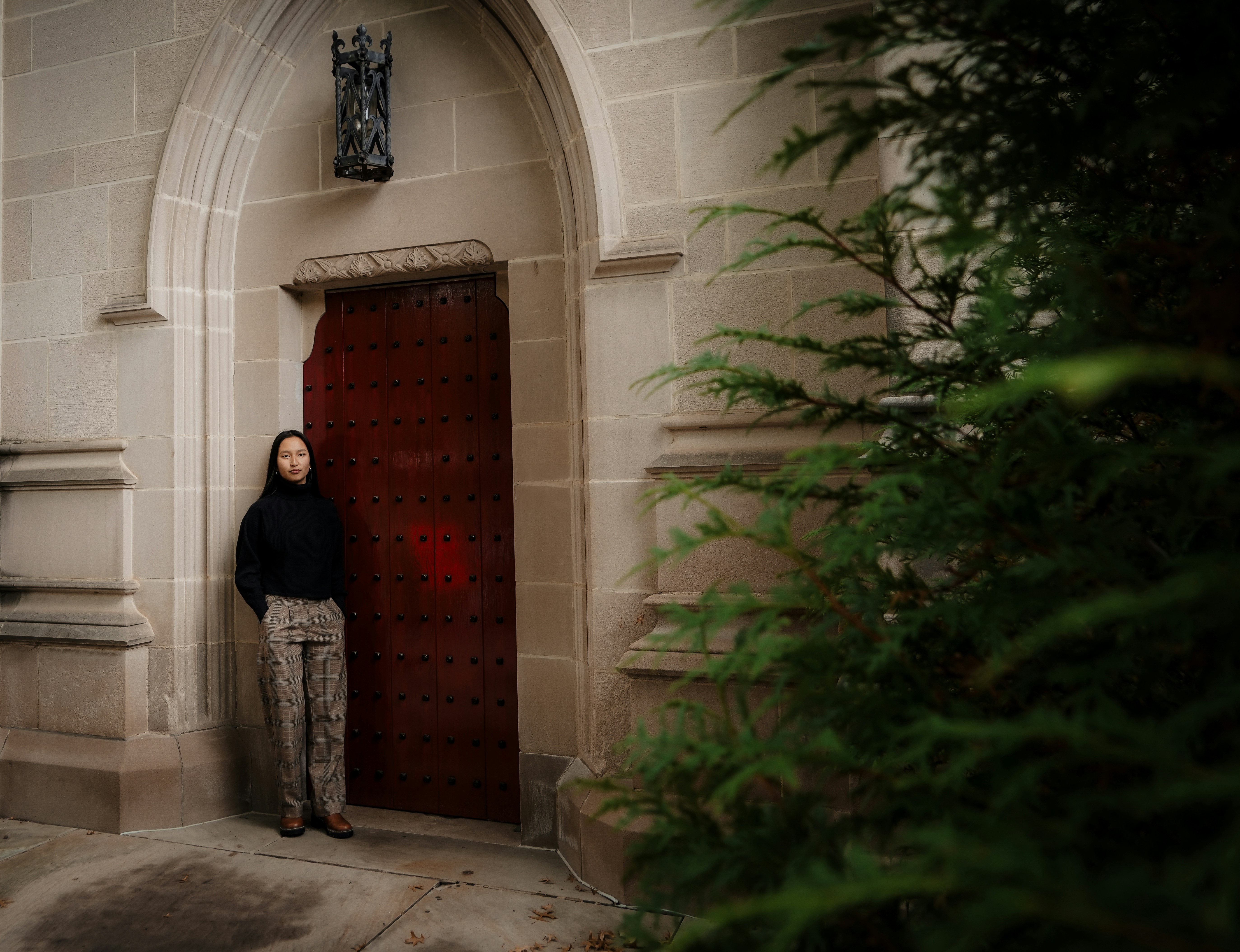 Threshold at the Red Door: A Quiet Portrait by Stone Archway