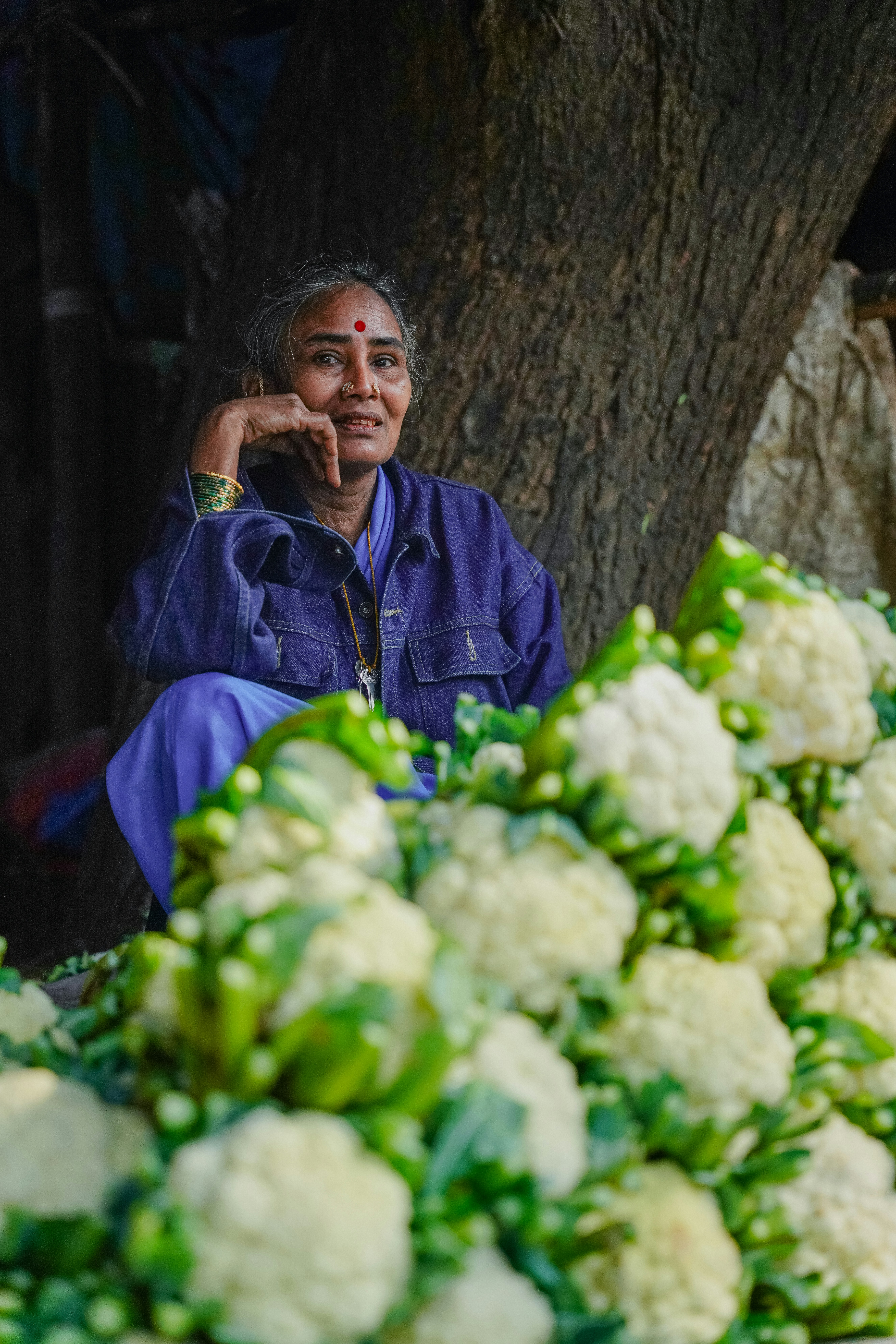 Resilience in Purple: A Market Portrait by the Cauliflower Pile