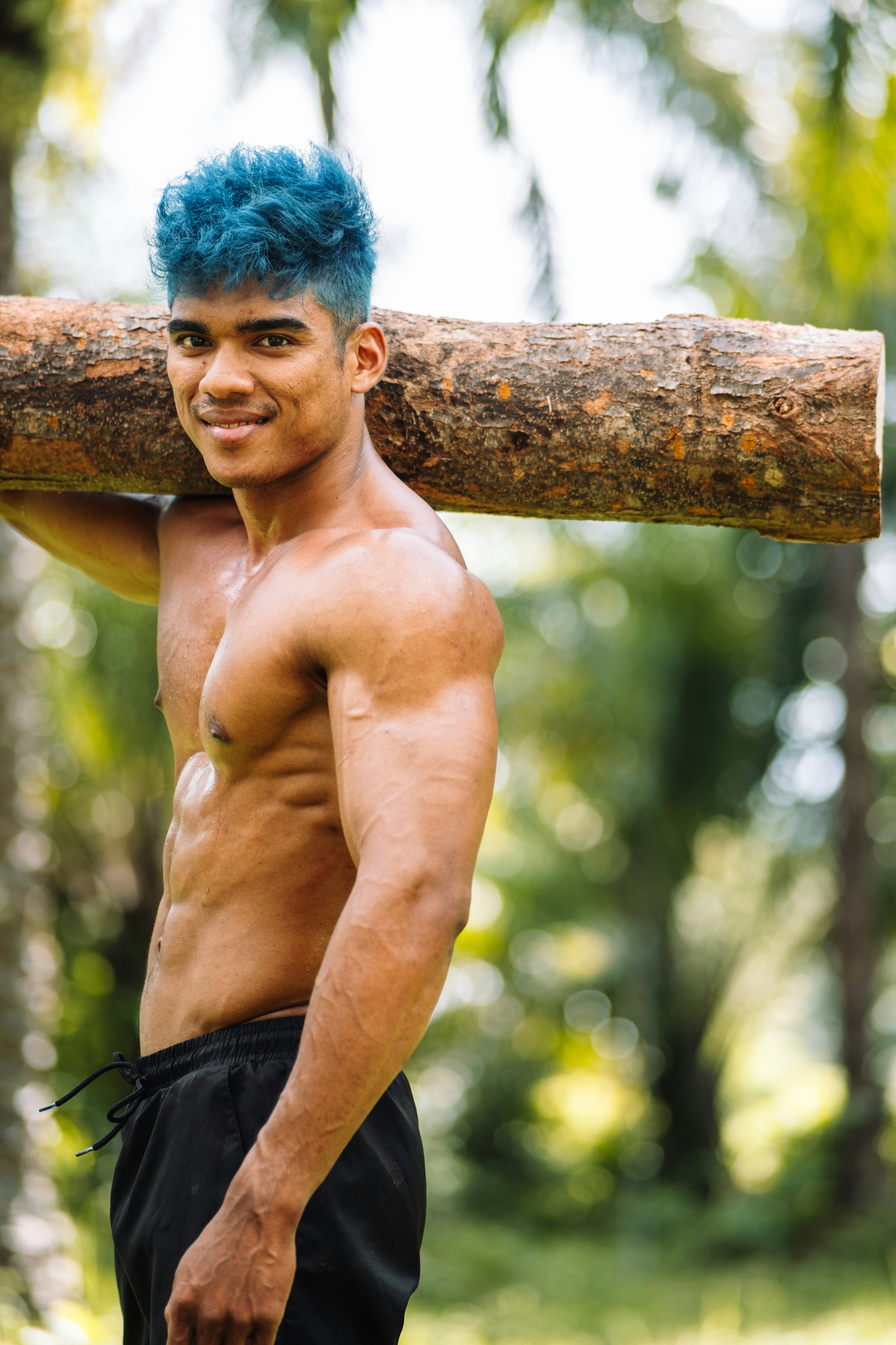 Un homme aux cheveux bleus portant une grosse bûche photo – Image ...
