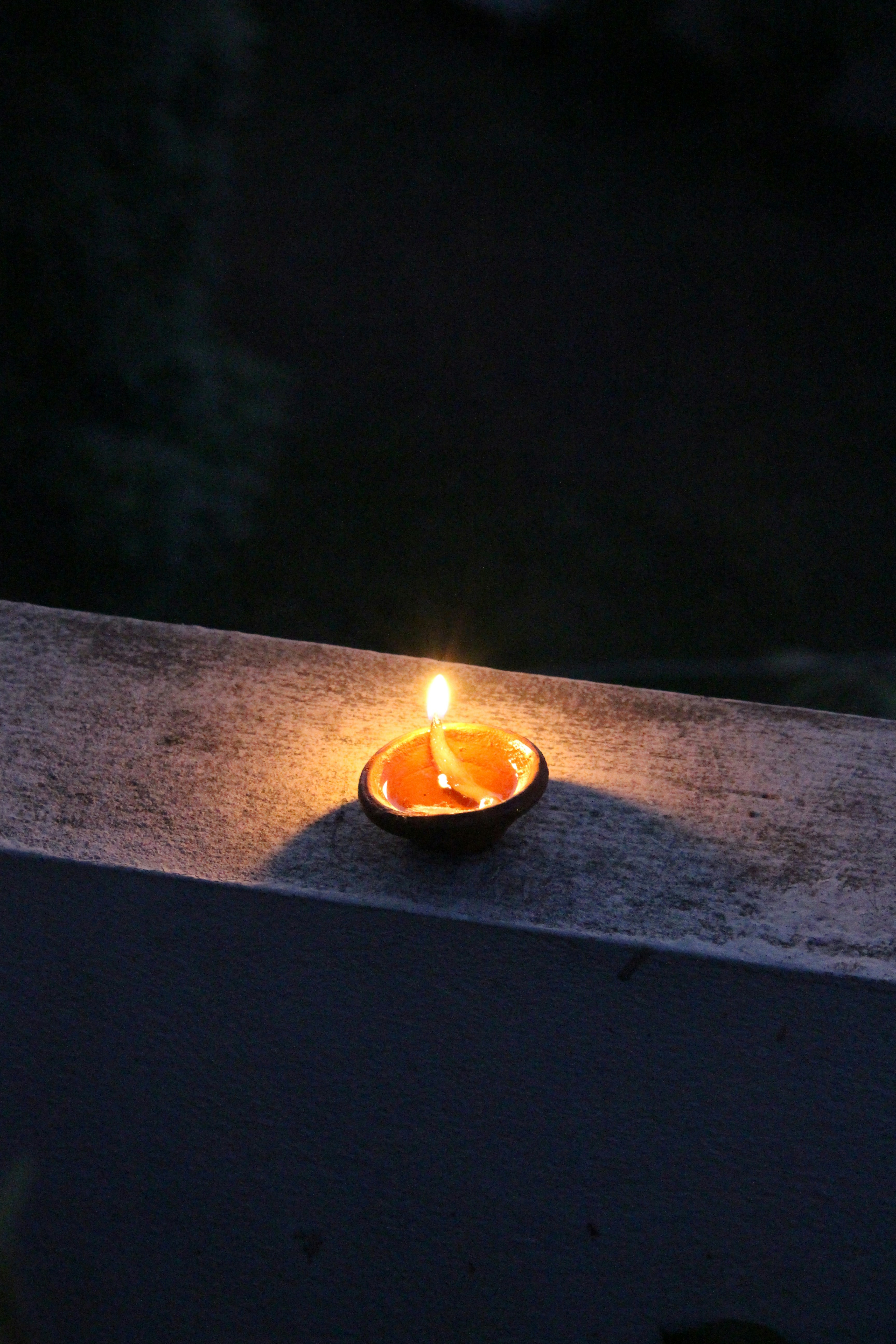 Single Diya on a Frosted Railing Under Nightfall