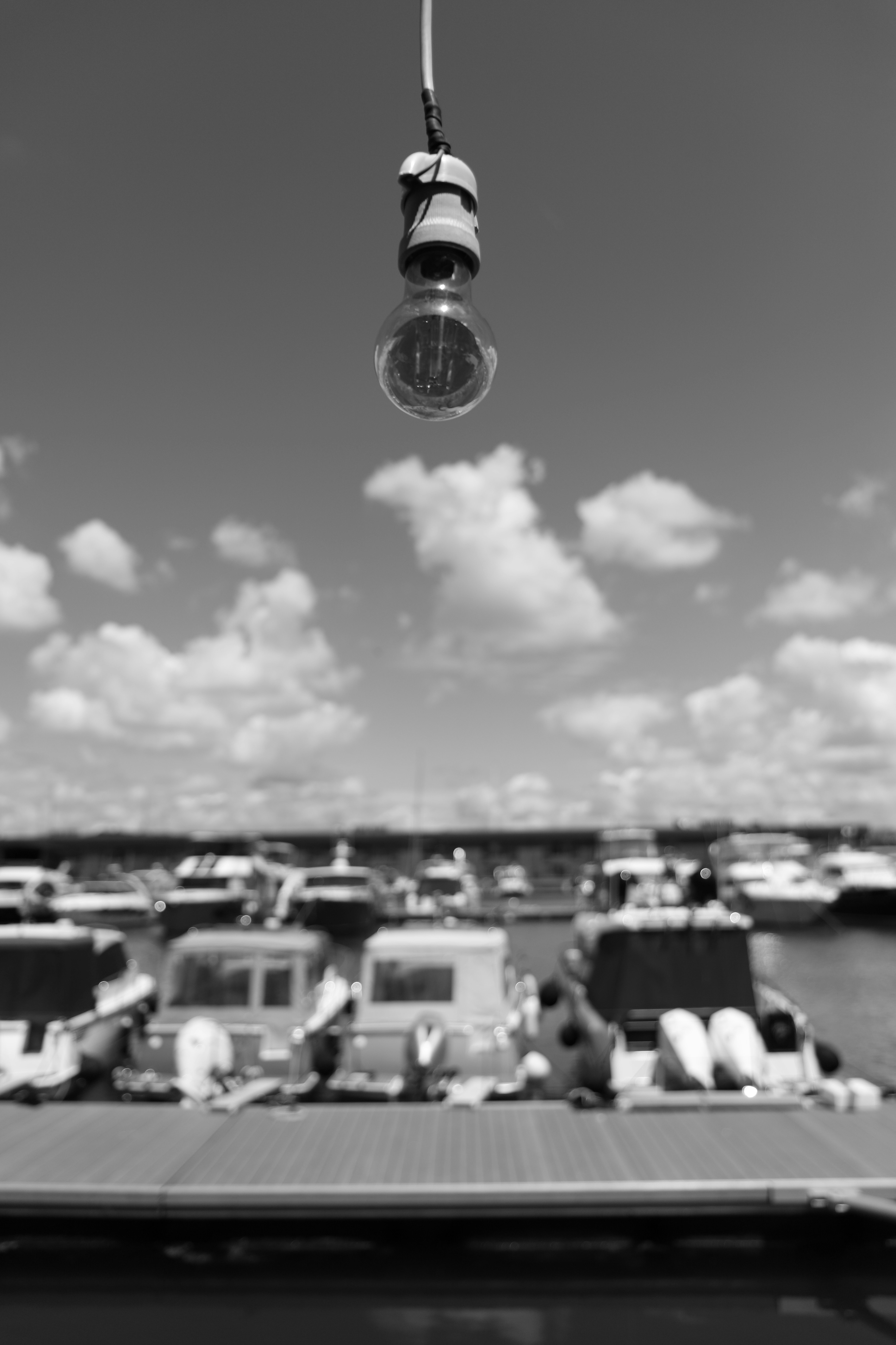 Lone Lightbulb Hovering Over a Quiet Marina in Monochrome