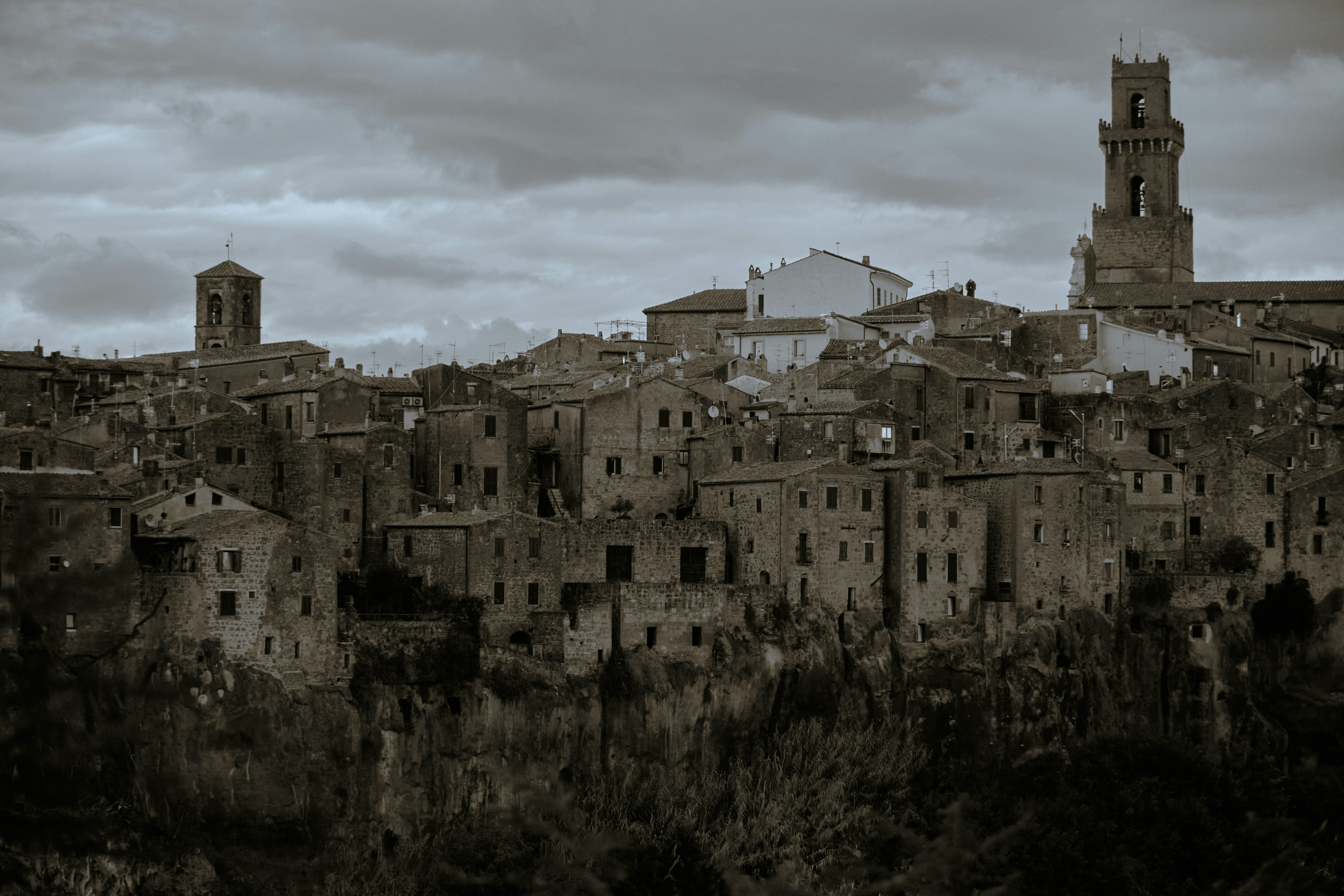 Stone Row on the Hill: A dusk-lit medieval town beneath a clouded sky