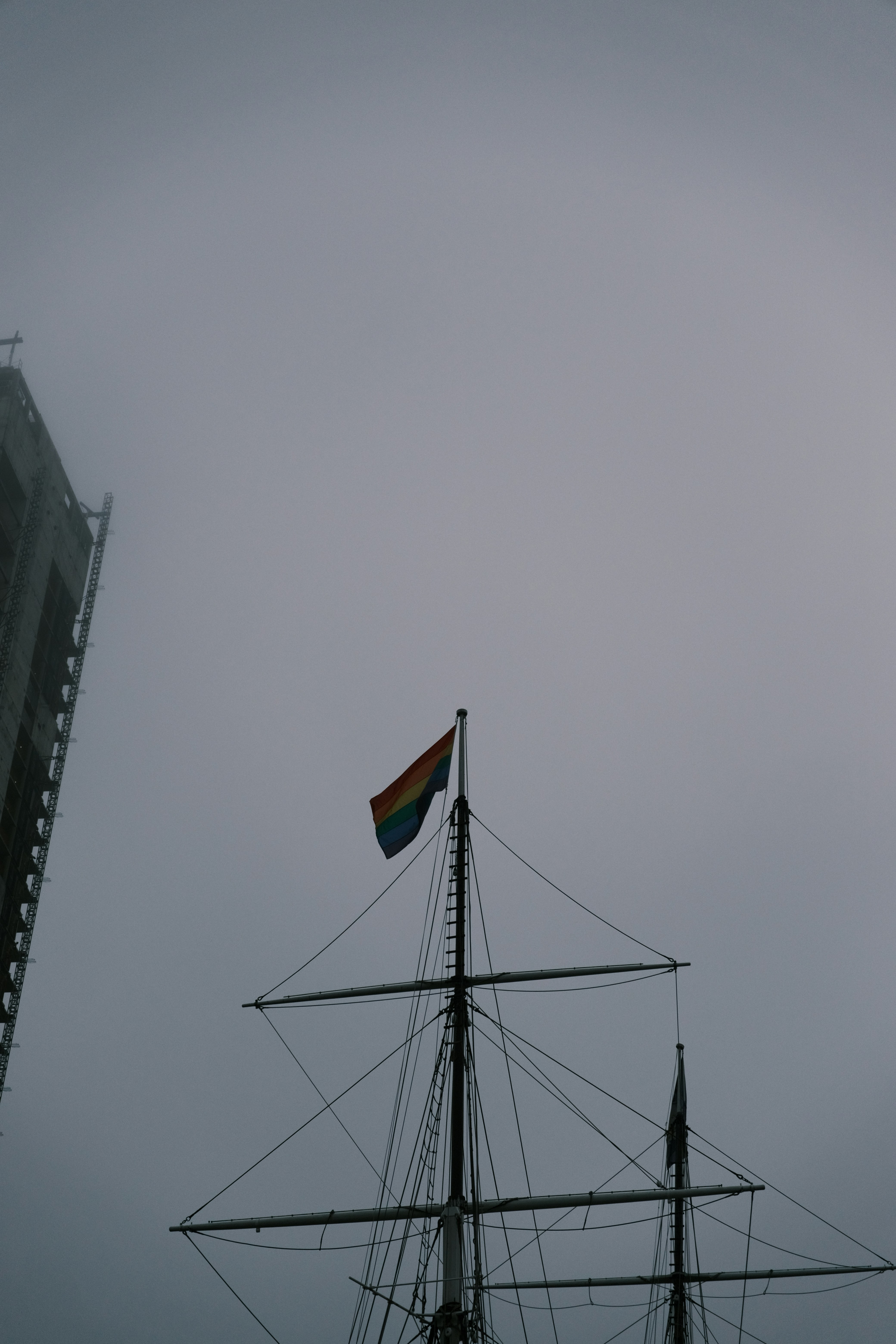 Flag Over the Mast: Pride Amid Industrial Silhouette