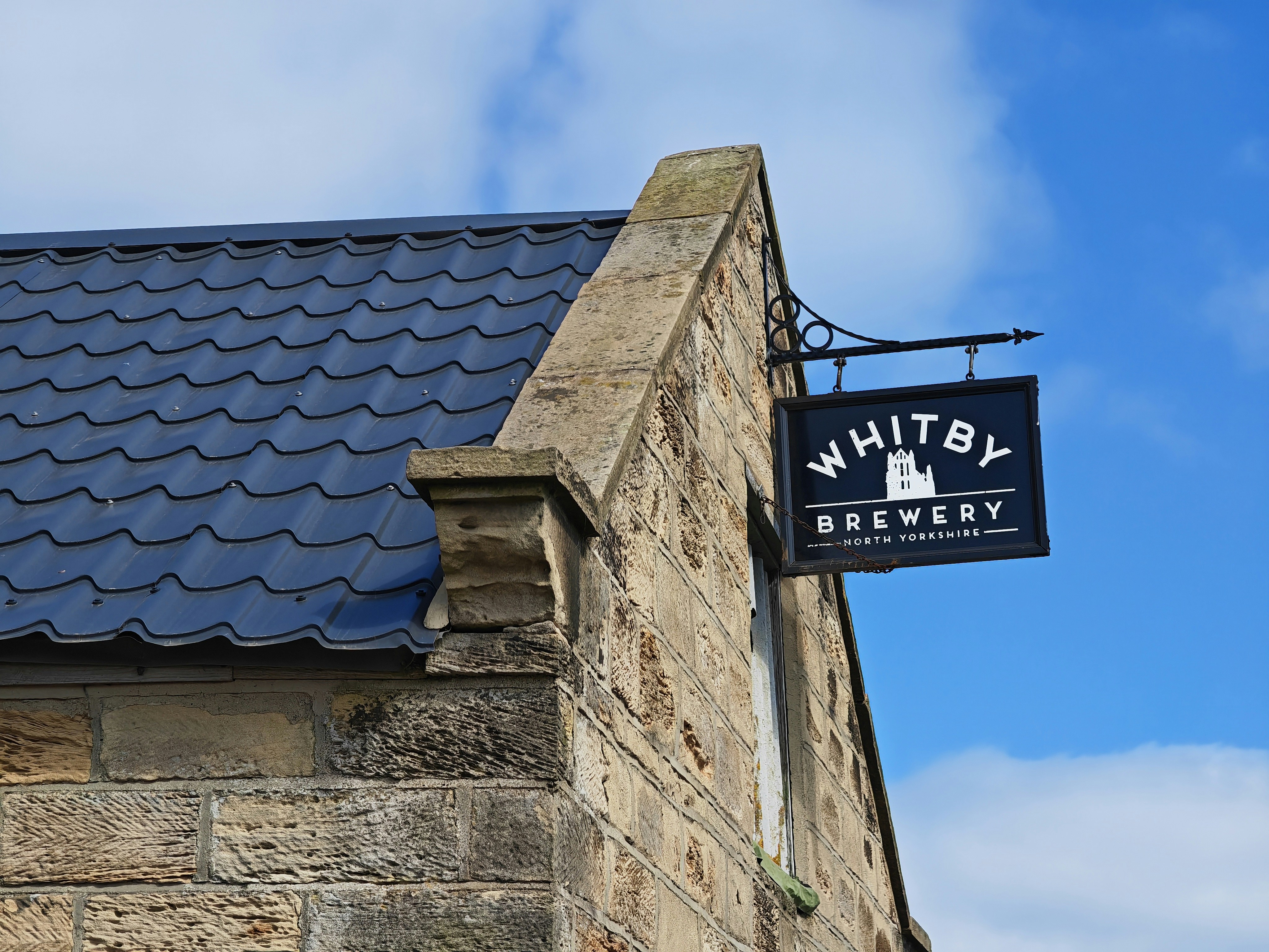 A sign hanging from the side of a building photo – Free Whitby Image on ...
