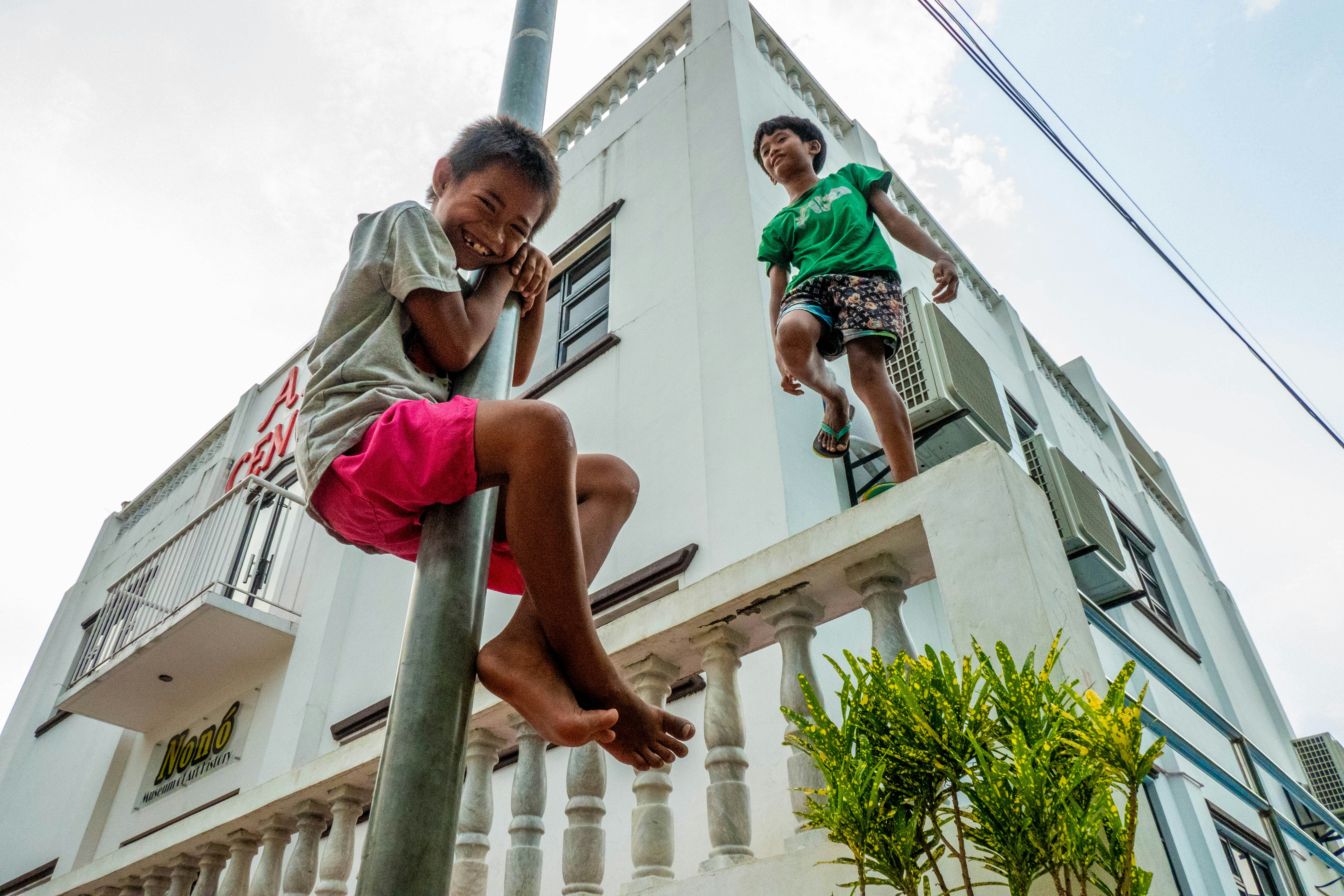 A couple of kids that are standing on a pole photo – Free Philippines ...