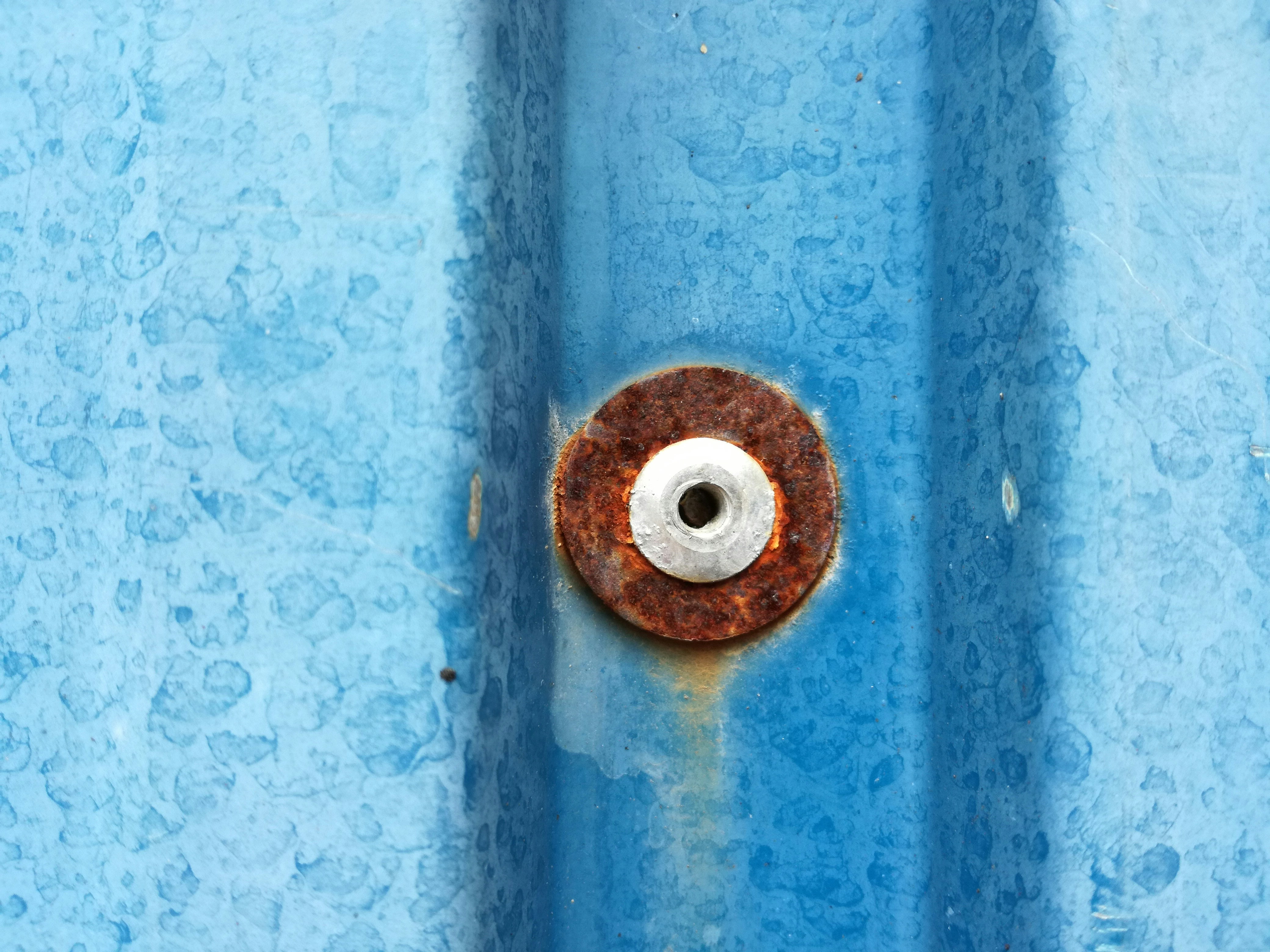 Rusty vent against weathered blue steel