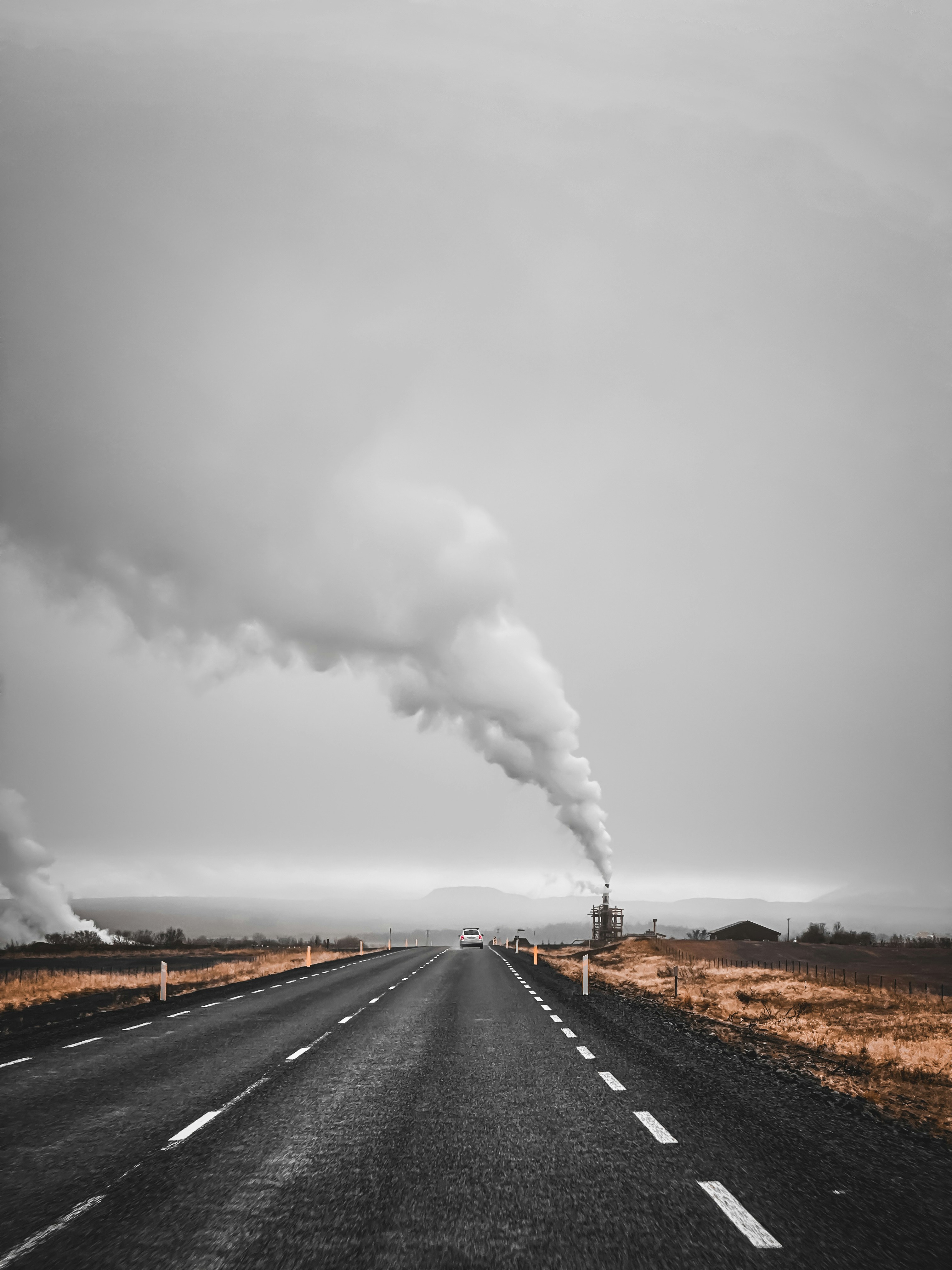 A black and white photo of a road with smoke coming out of it photo ...