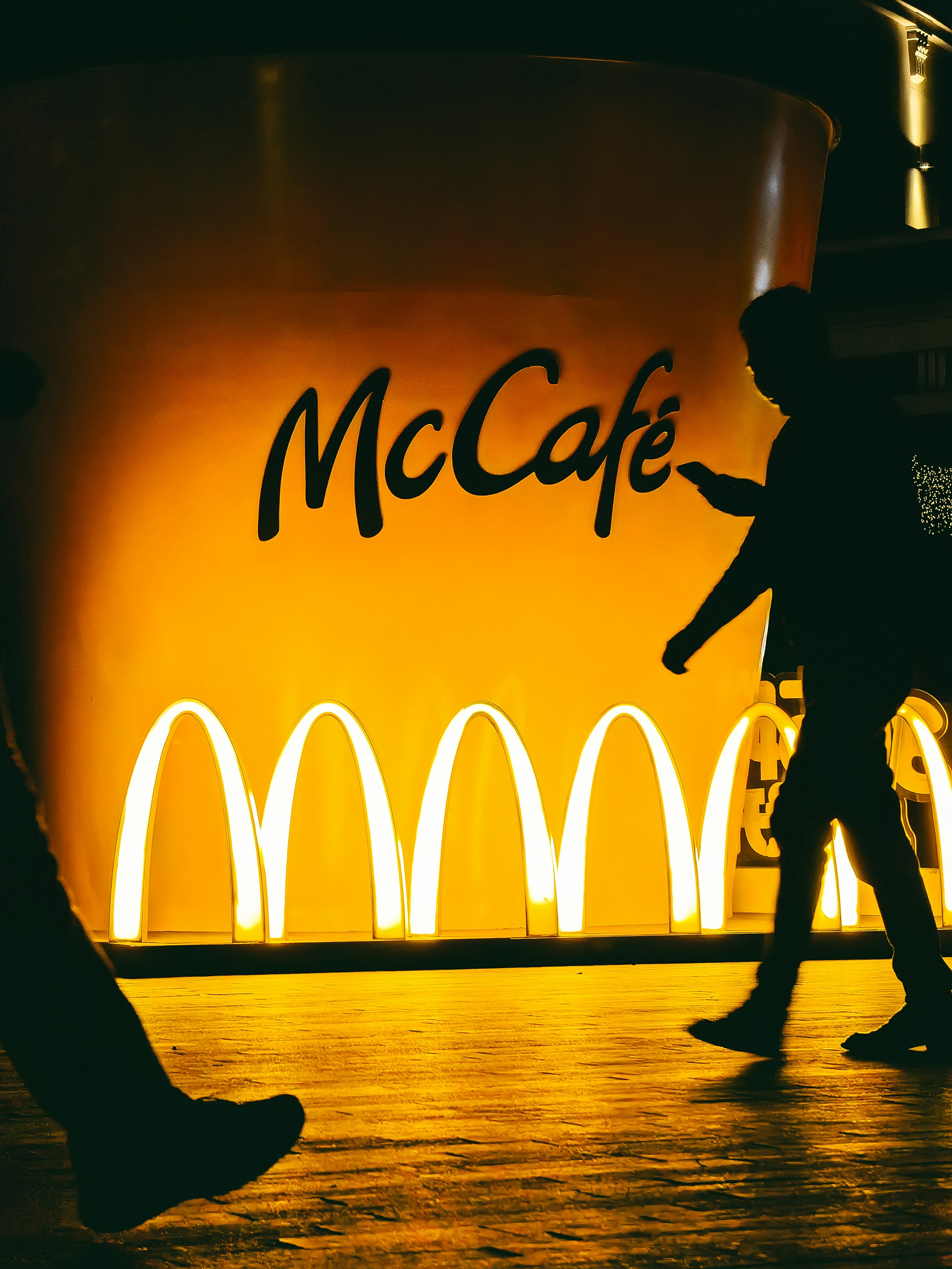 A person walking in front of a mcdonald's sign photo – Free Street ...