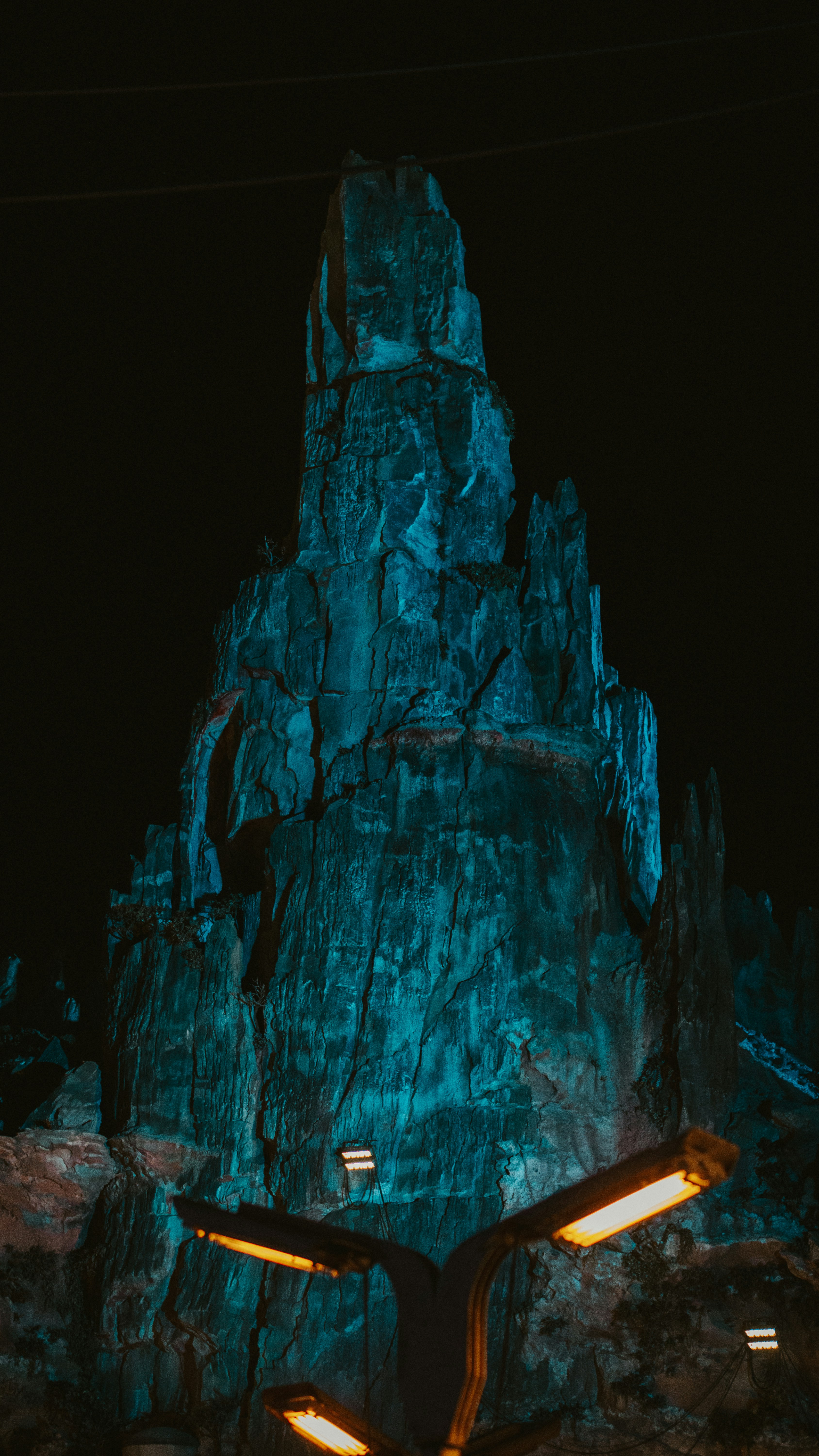 A large rock formation lit up at night photo – Free Disney's hollywood ...