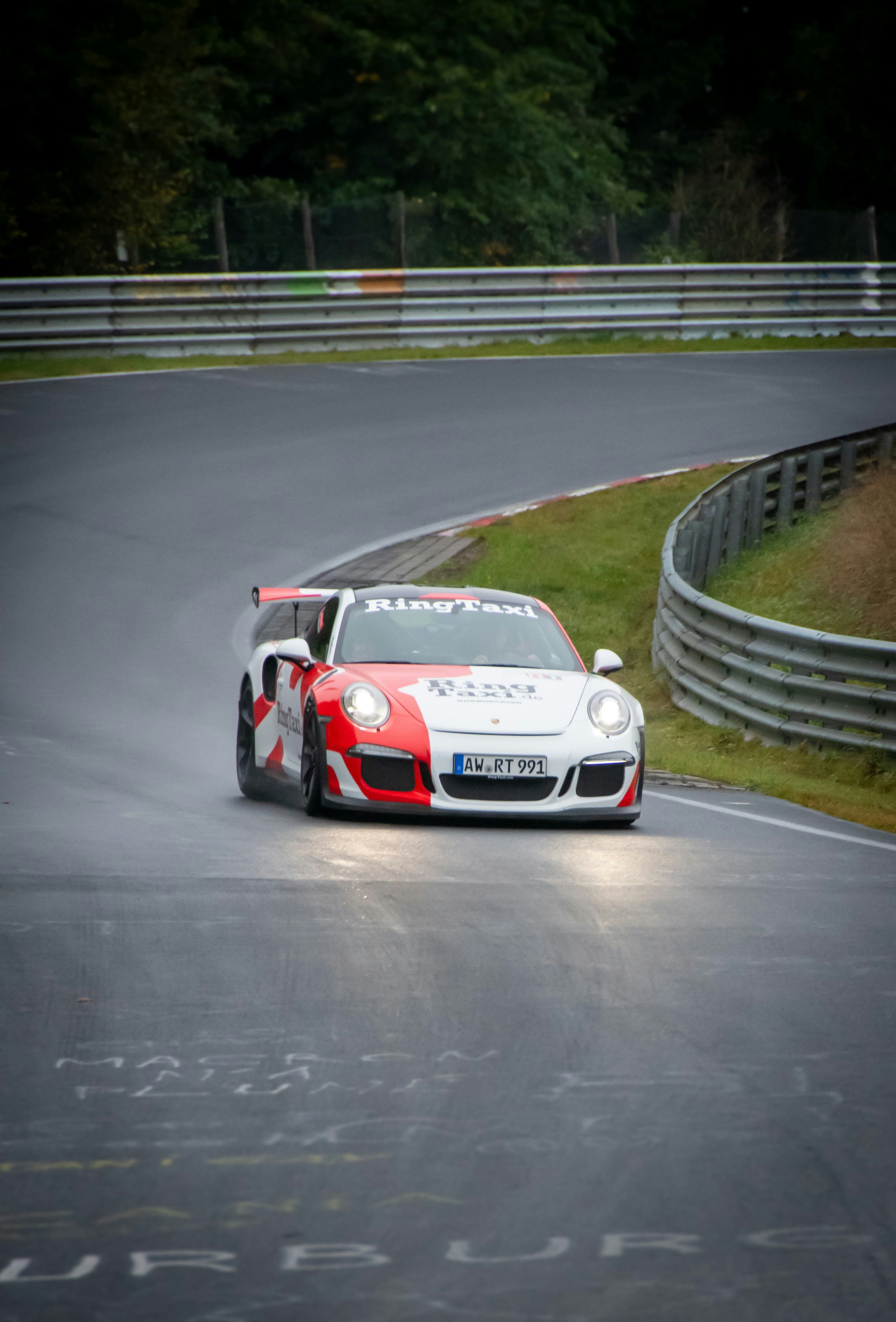 A red and white car driving down a race track photo – Free Nürburgring ...