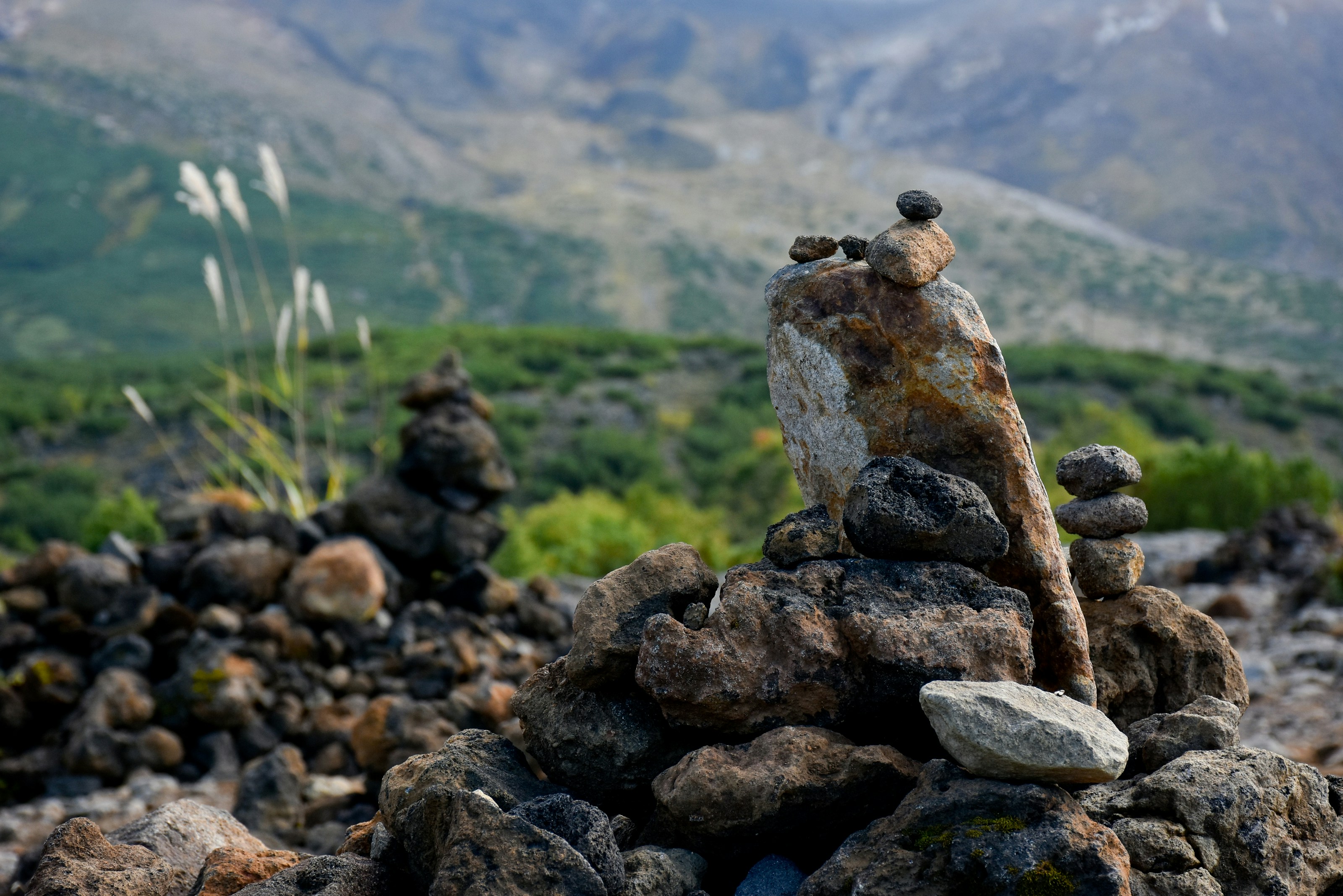 A carefully arranged stack of stones amidst a rugged landscape, showcasing the harmony between nature and human creativity.